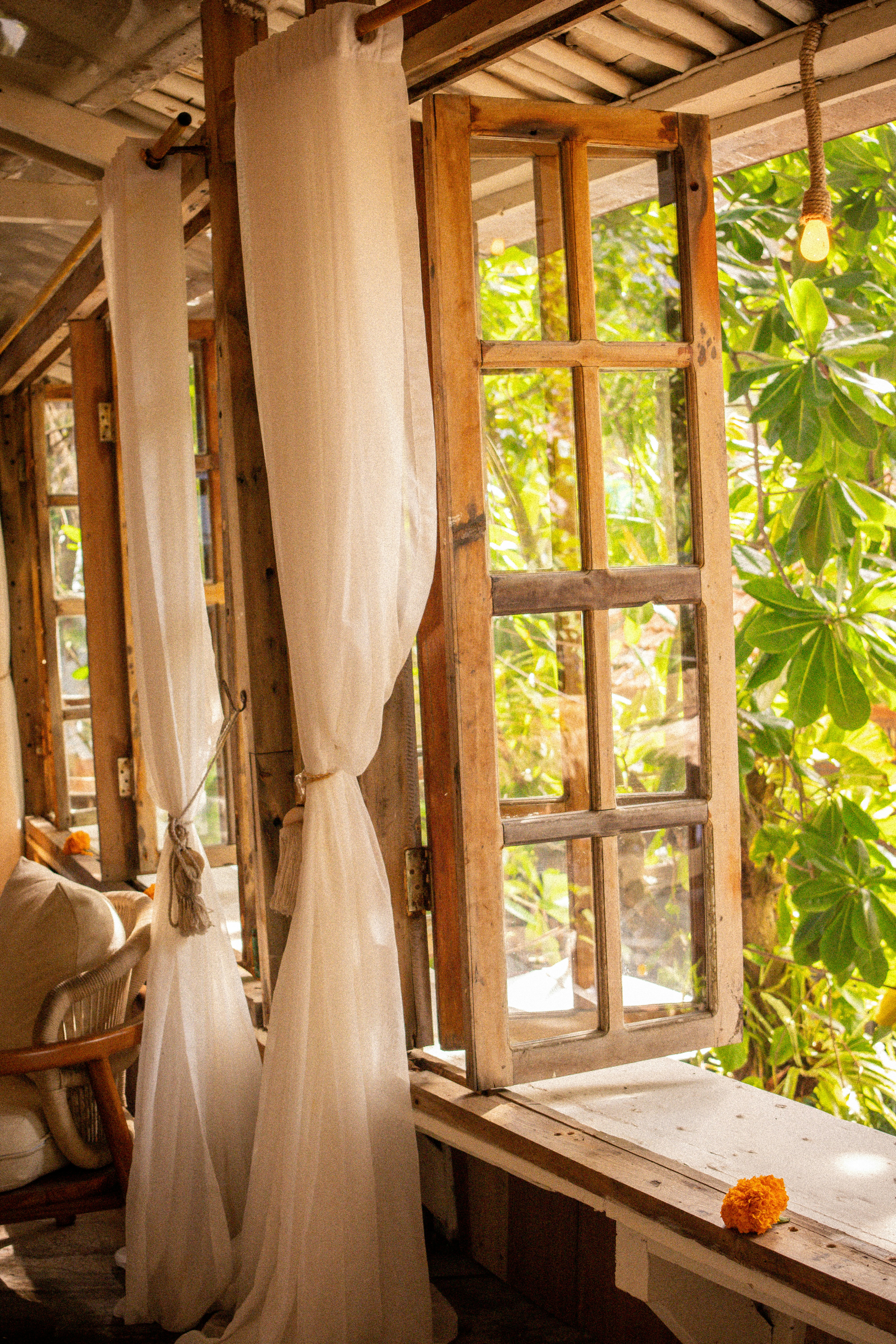 Sunlit Veranda with Flowing White Drapes and Greenery