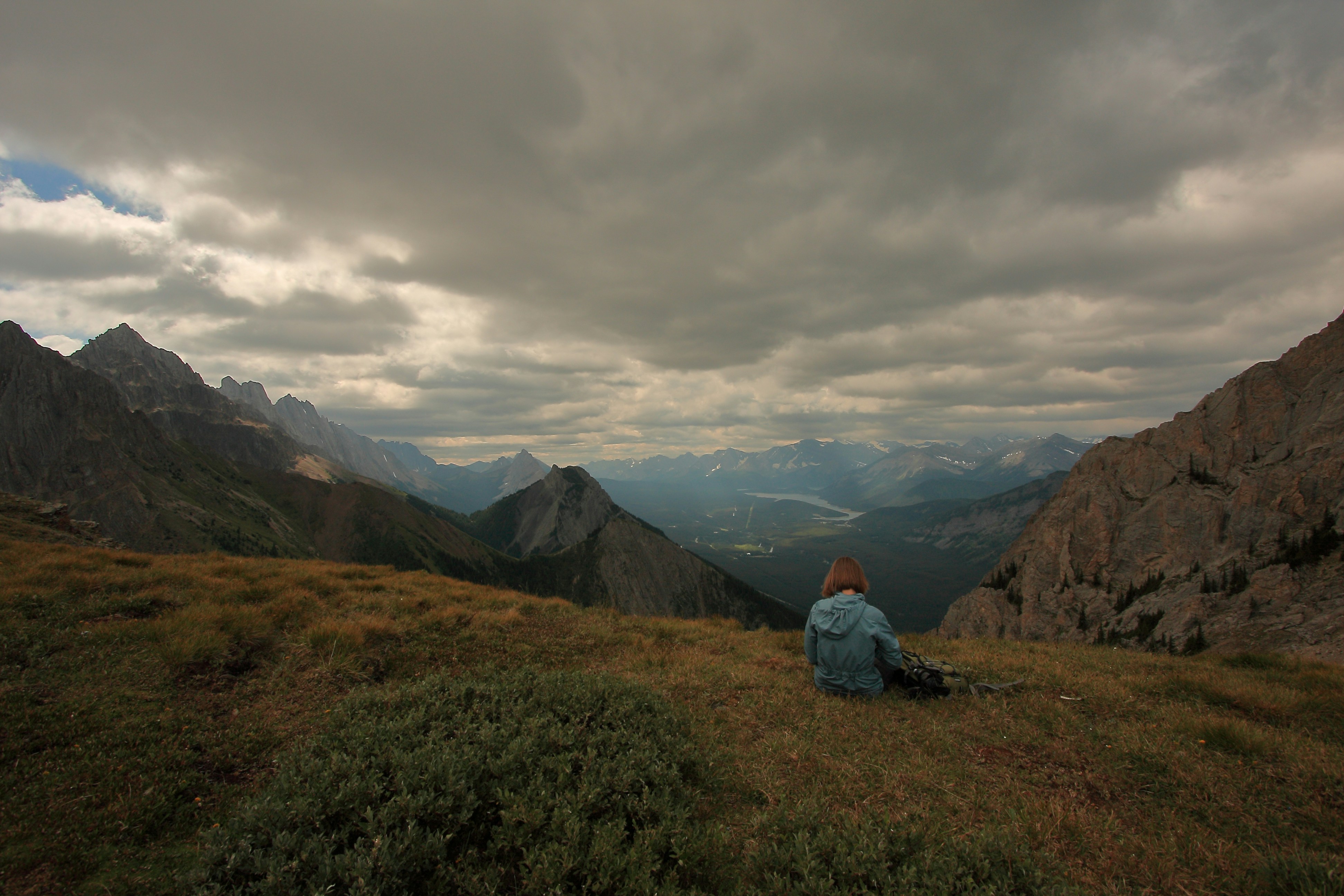 Horizon Seated: A lone hiker at the edge of the alpine overlook