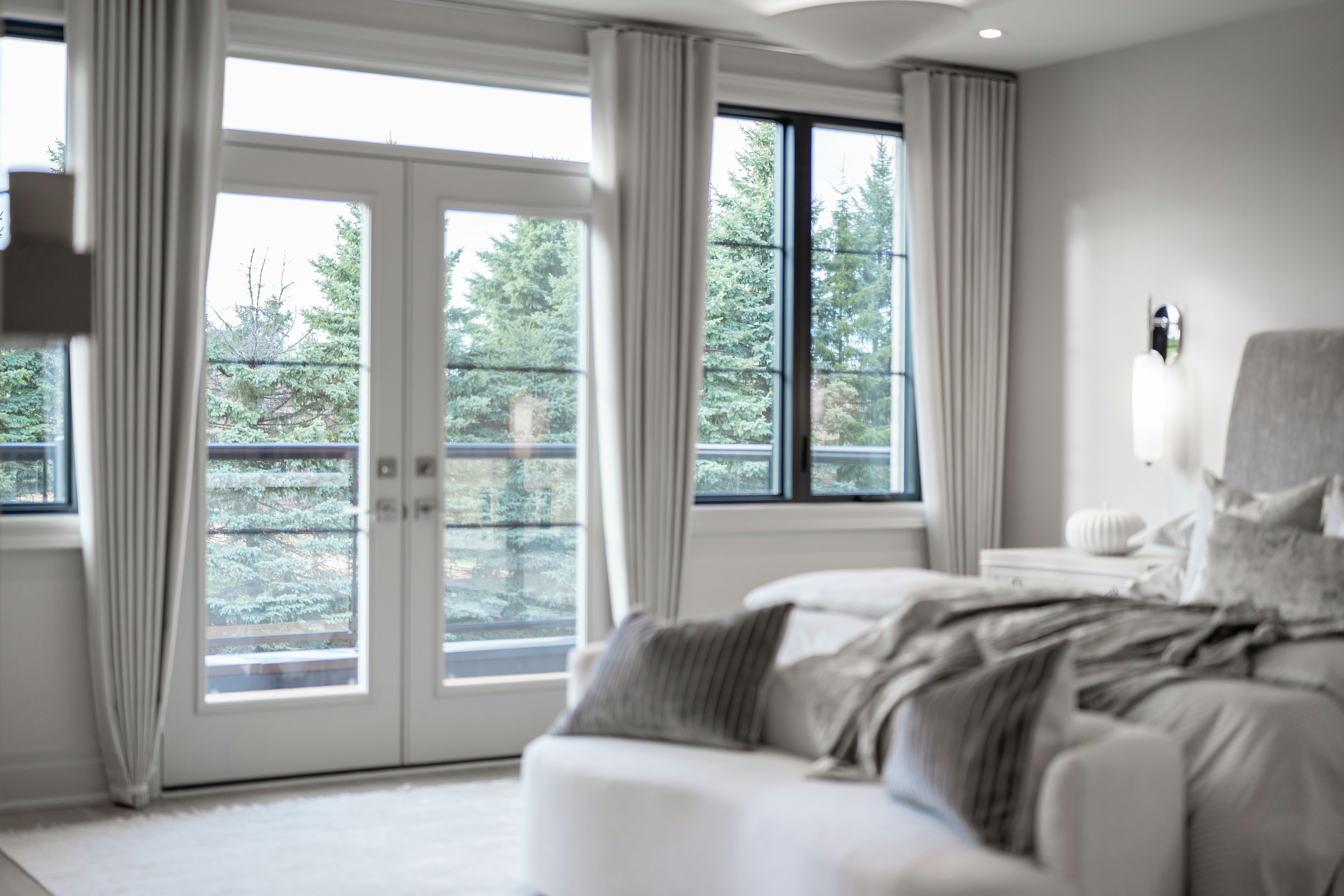 Sunlit Suite: Neatly Made Bed with Glass Doors to a Tranquil Balcony