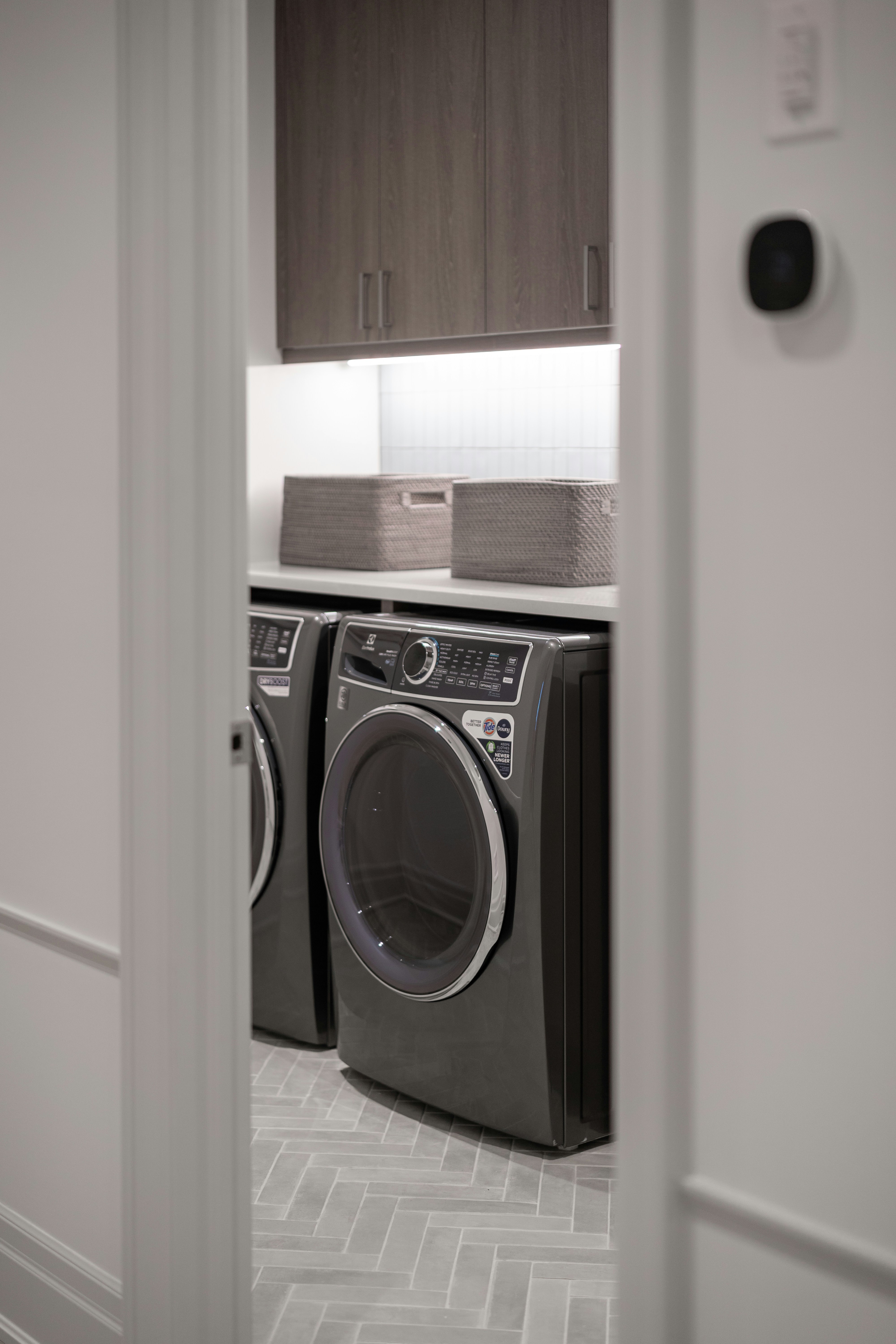 Hidden Laundry Nook: Laundry pair beneath a soft-lit Cabinet