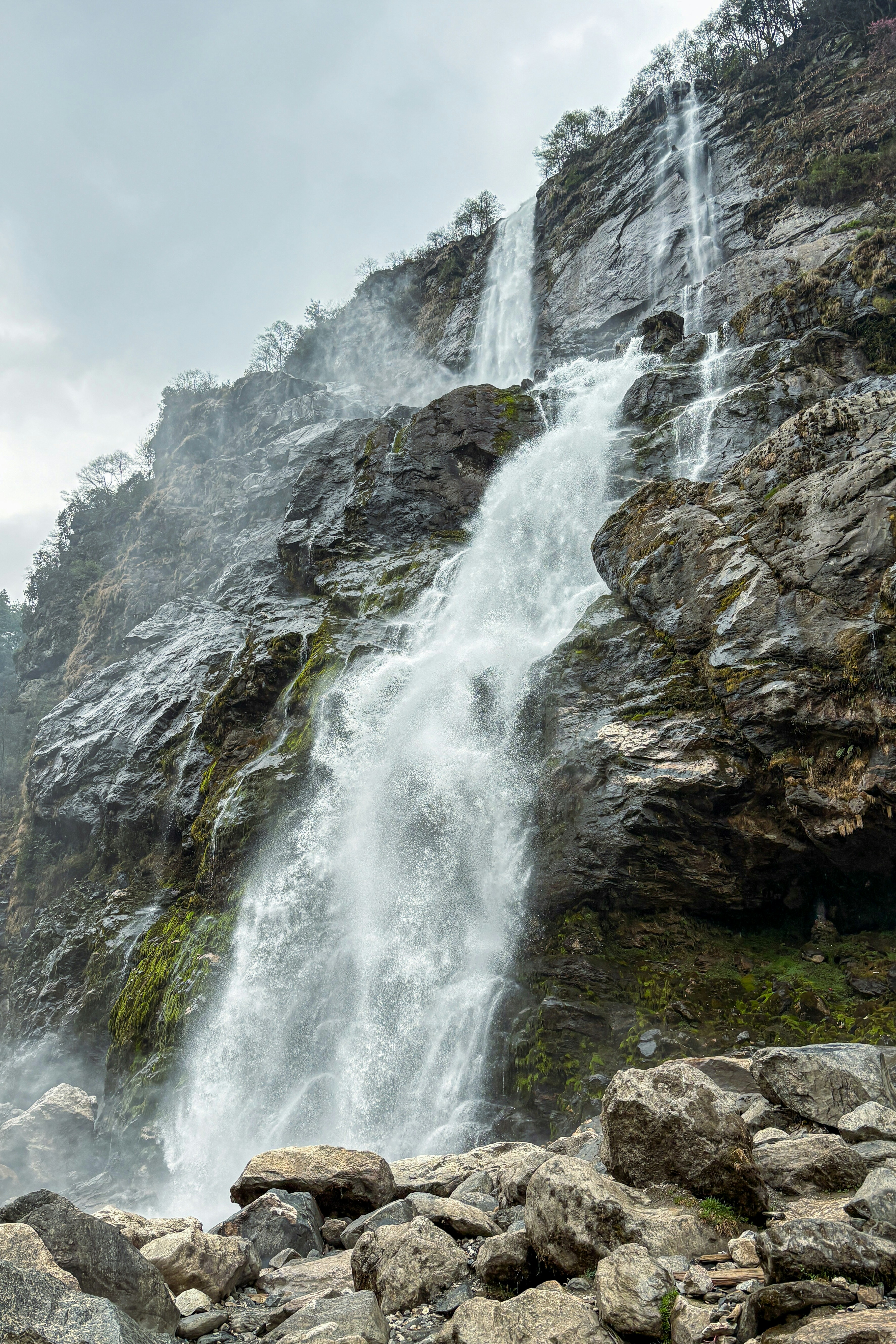 Cascading Veil: A Mountain Falls Surge Over jagged Rocks