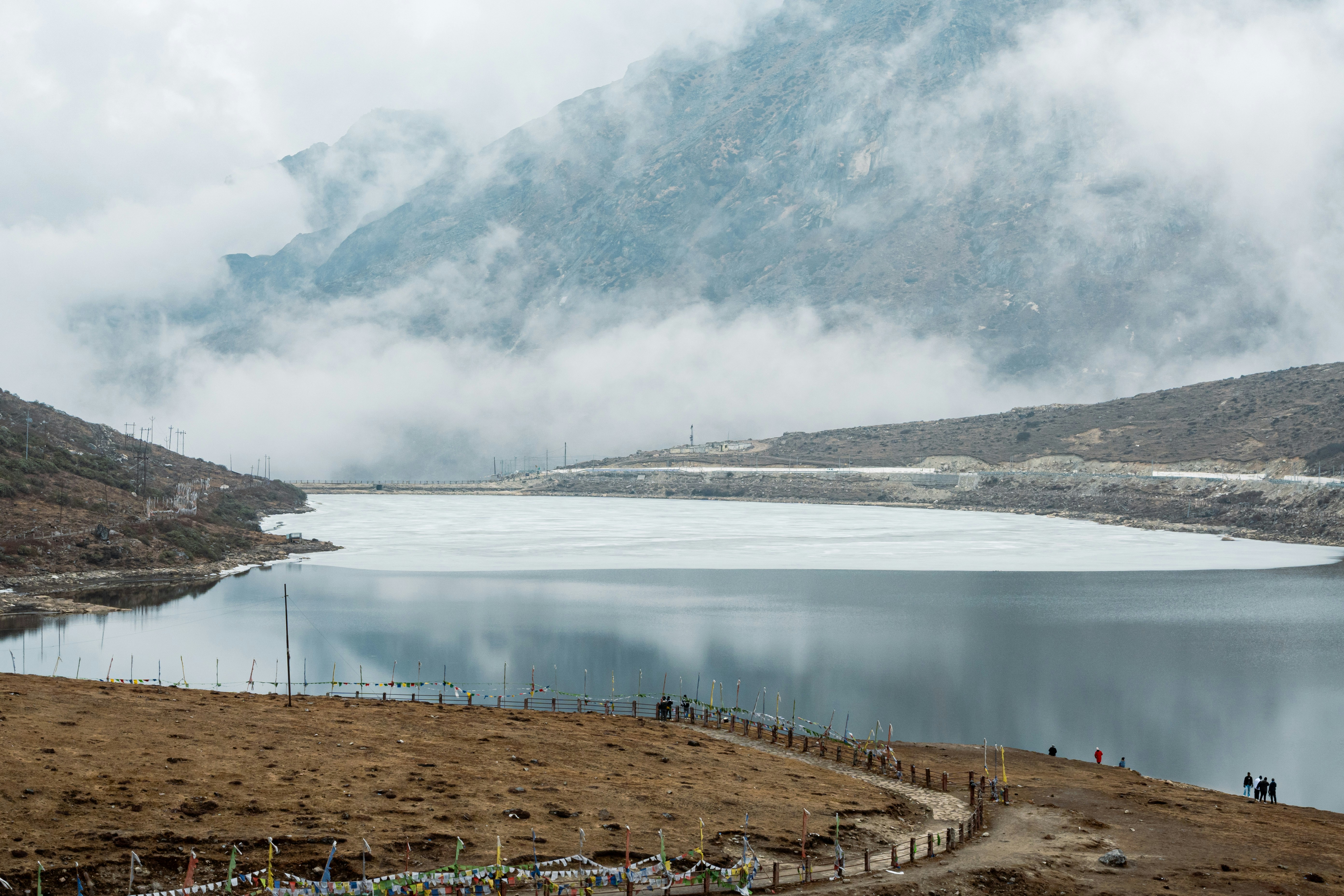 Mist over a glacial lake: path through the barren mountains