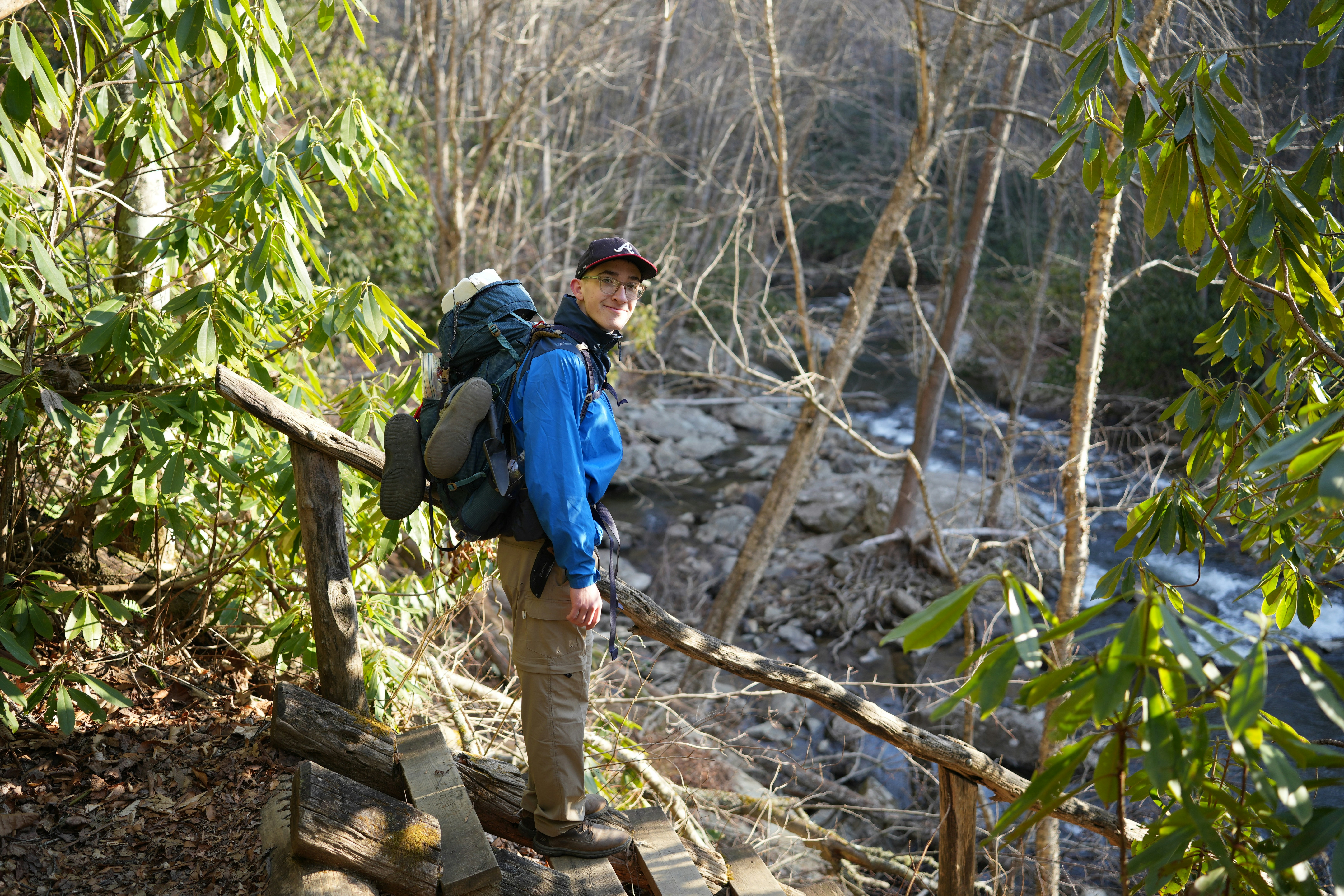 Trailbound explorer on a wooden overlook above a river canyon