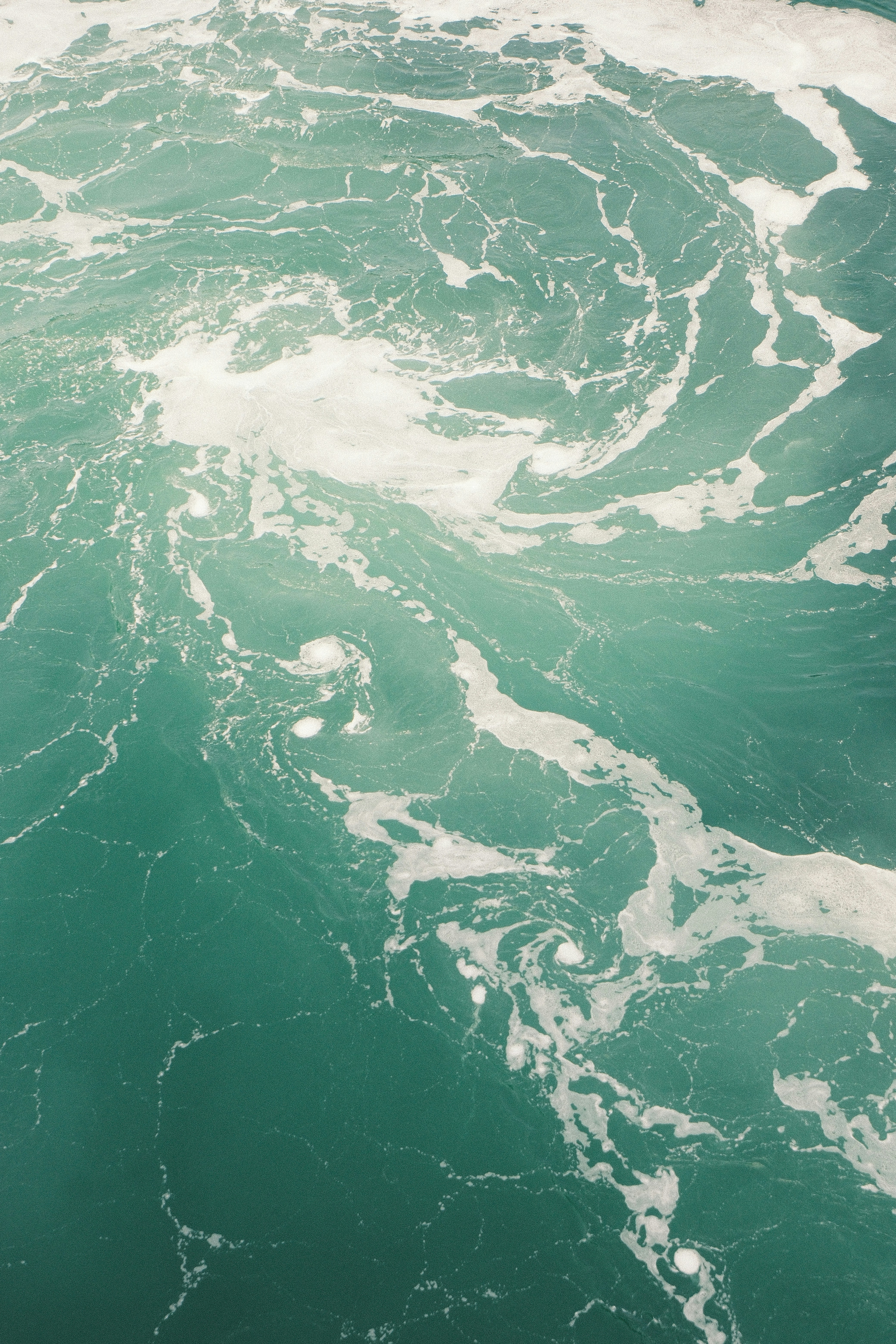 Turquoise Whirl: Foam Trails in Open Sea