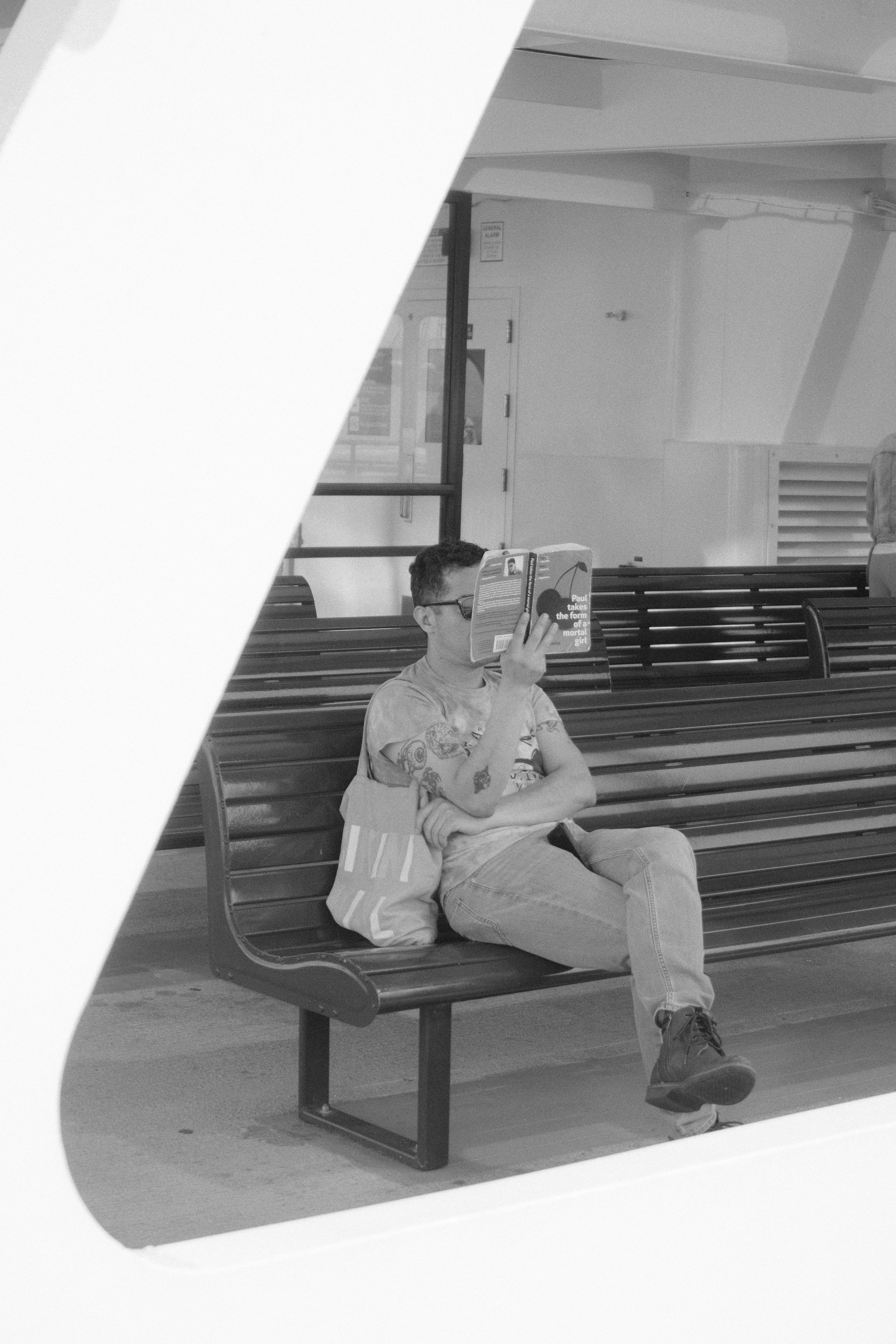 Reader on the Bench: A Quiet Moment Amid Modern Architecture