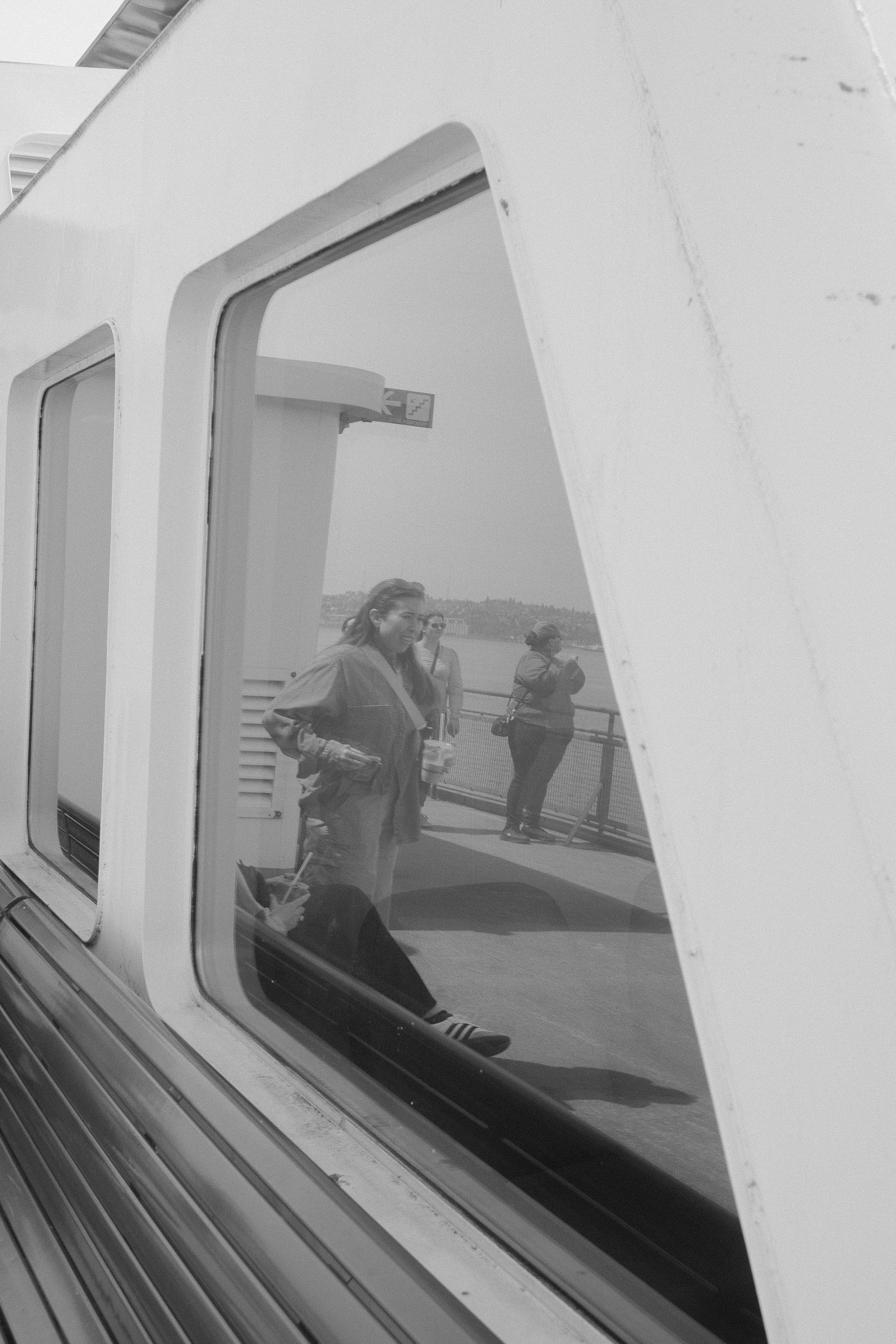 Reflections on the Deck: Passengers and Silhouettes Within a Vessel Window