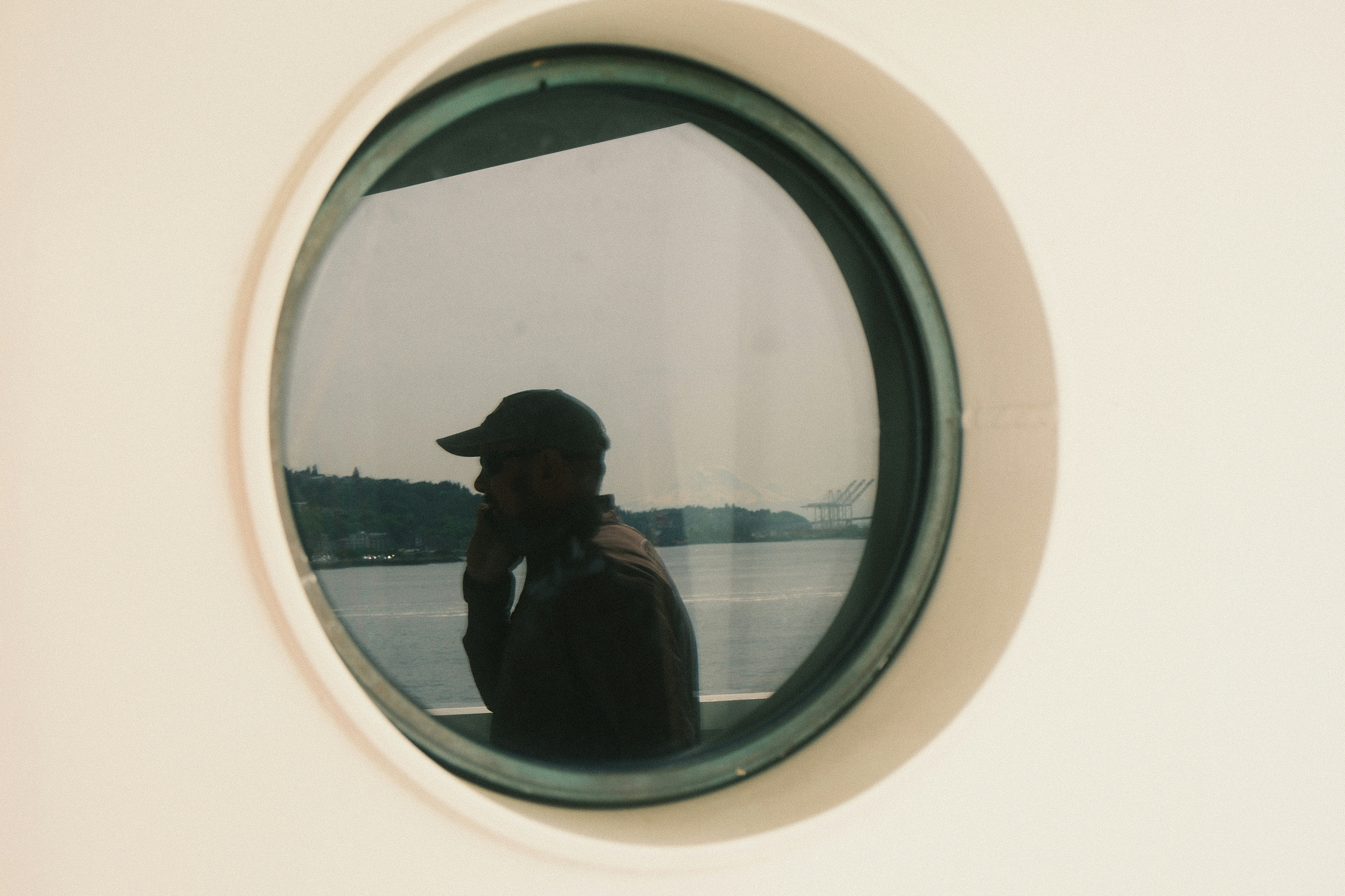 Circular Window Reflection: Portrait in Quiet Harbor