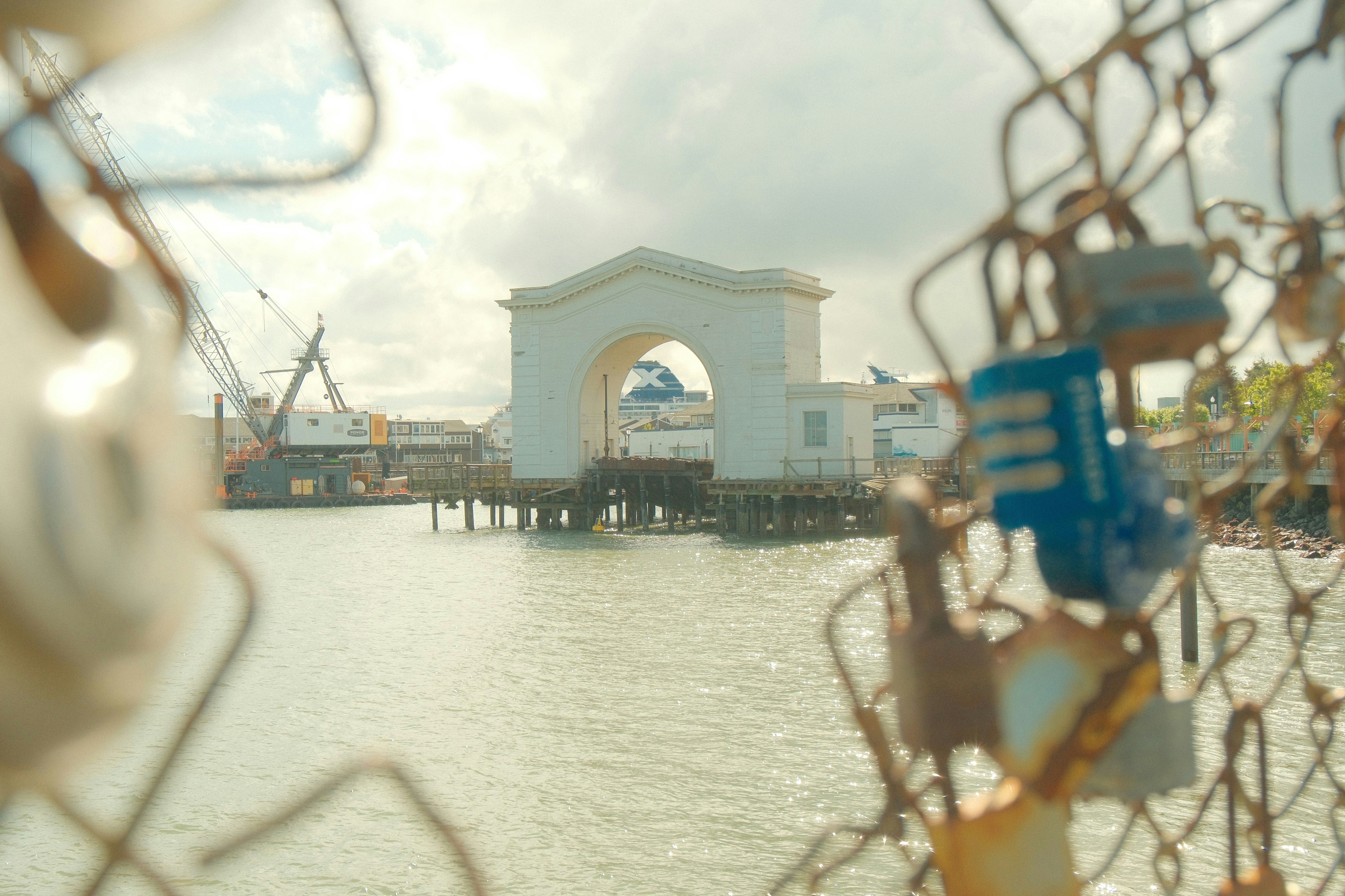 Archway Pier: A Quiet Moment Through a Chain-Link Frame