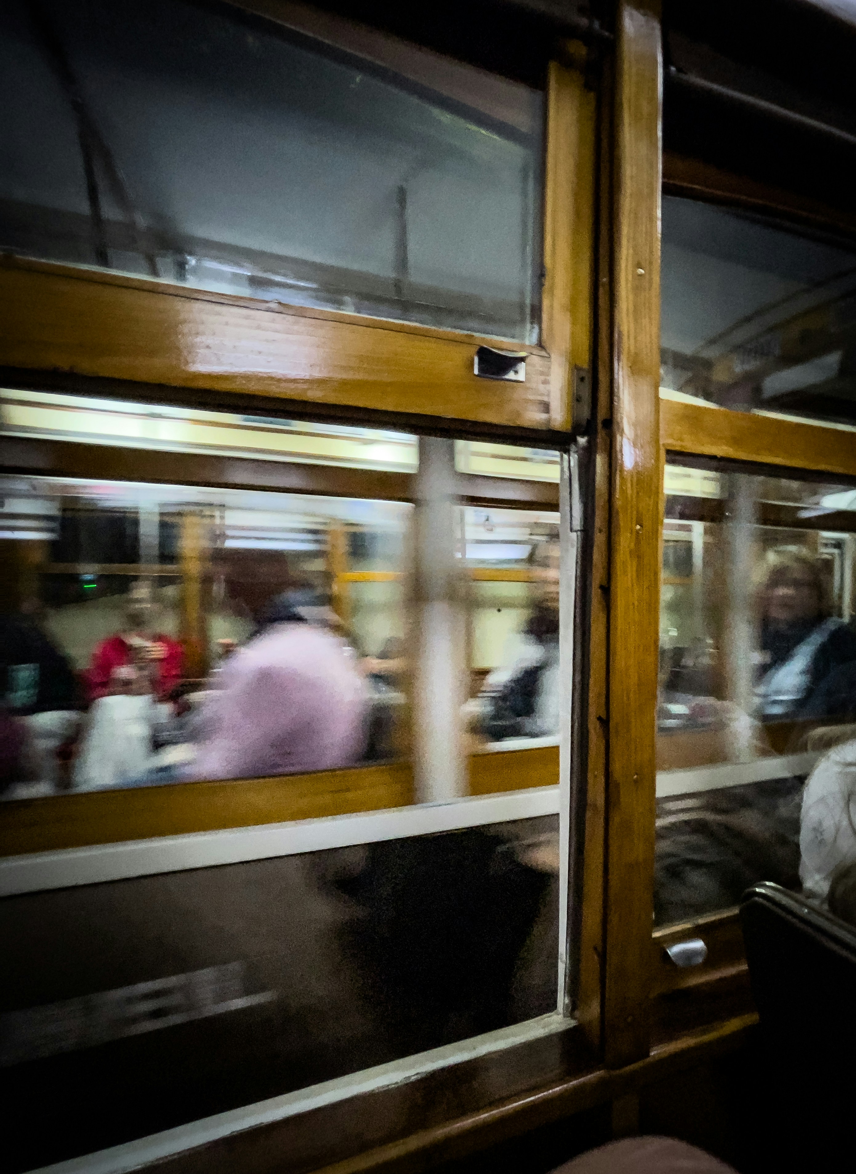 Inside a Moving Carriage: Blurred Windows with Wooden Frames and Passengers