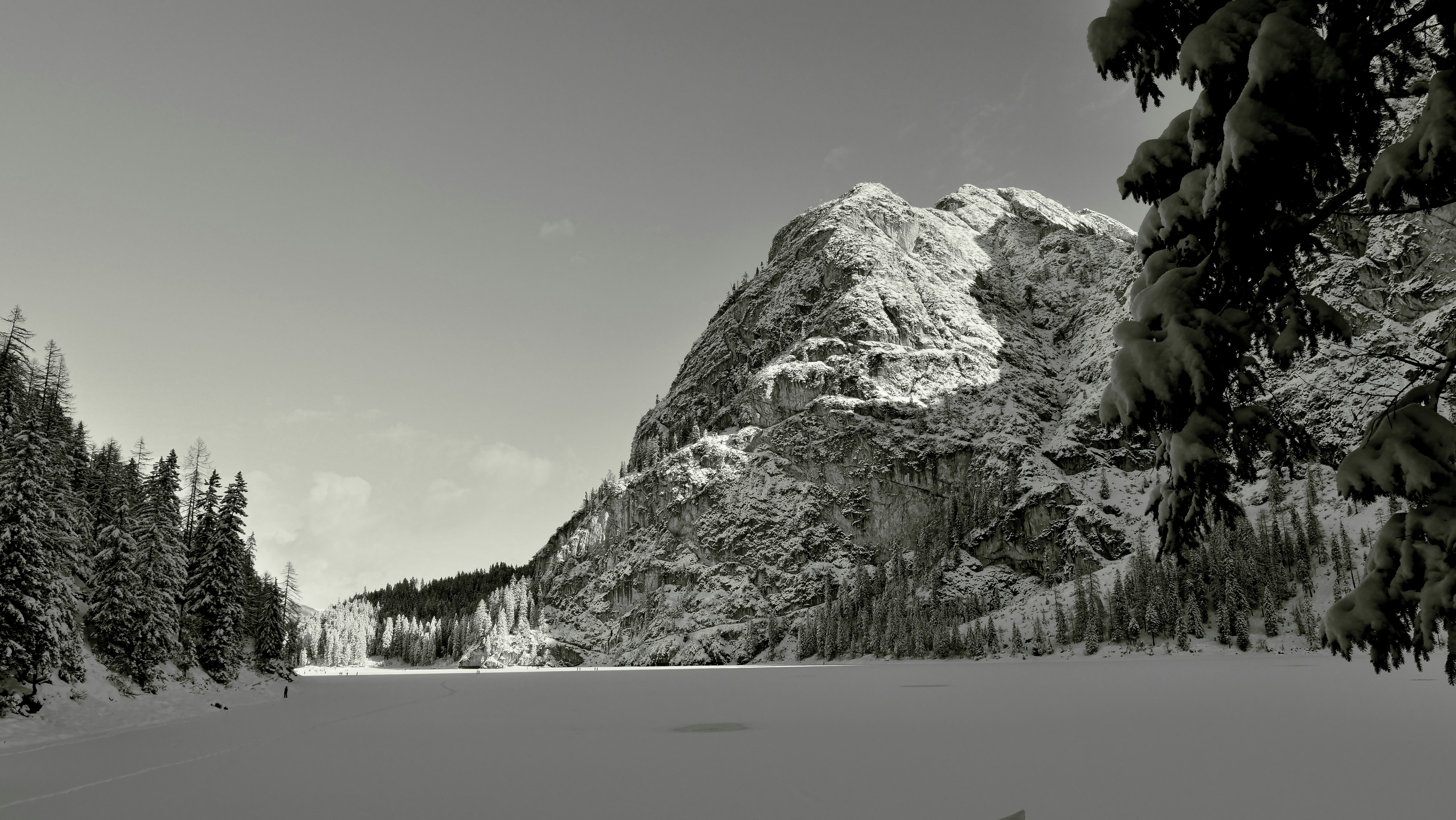 Snowbound Monolith: A Lone Stream of Light at the Foot of the Peak