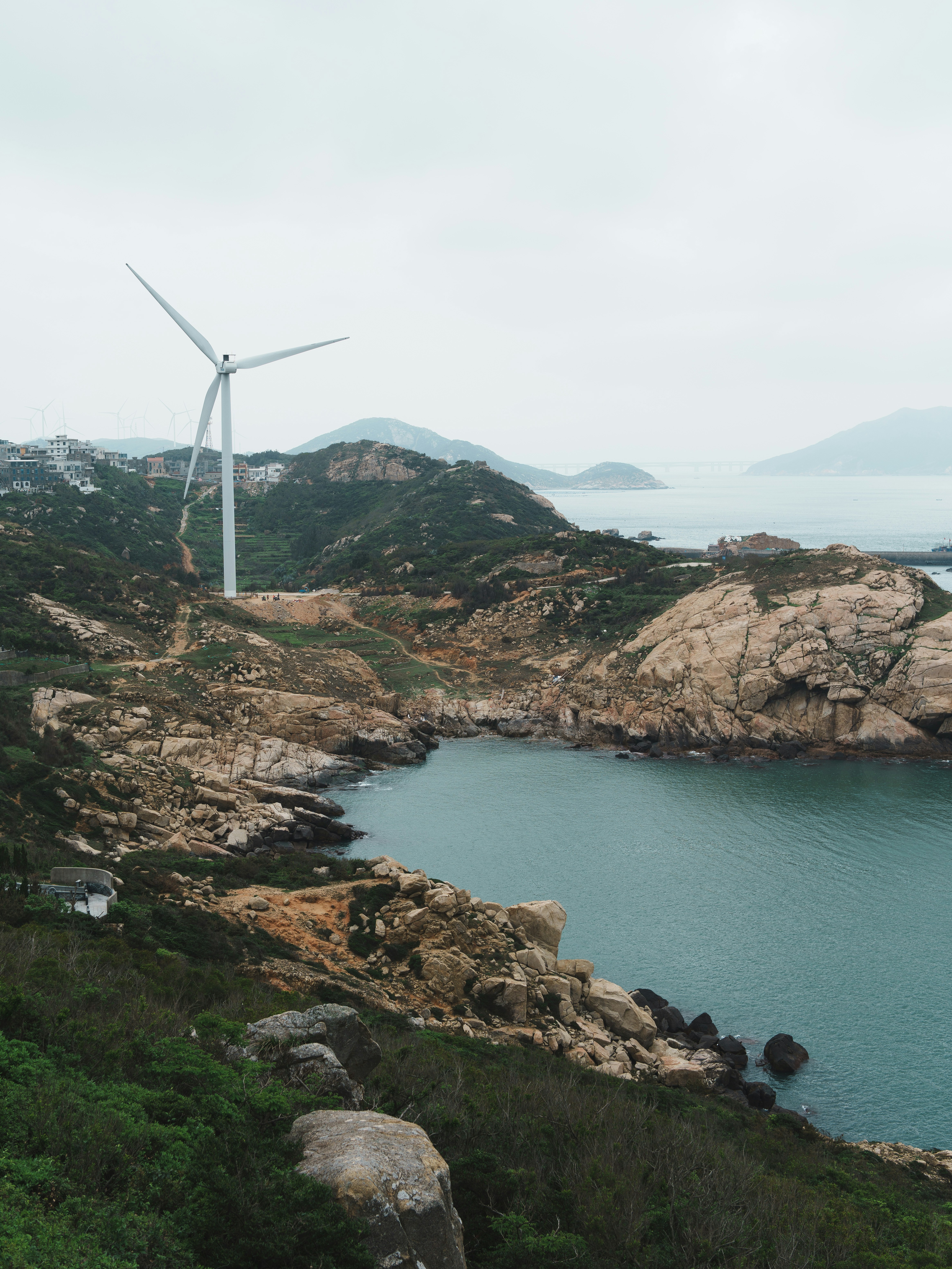 Windward Coast: A Lone Turbine Over Coastal Rocks