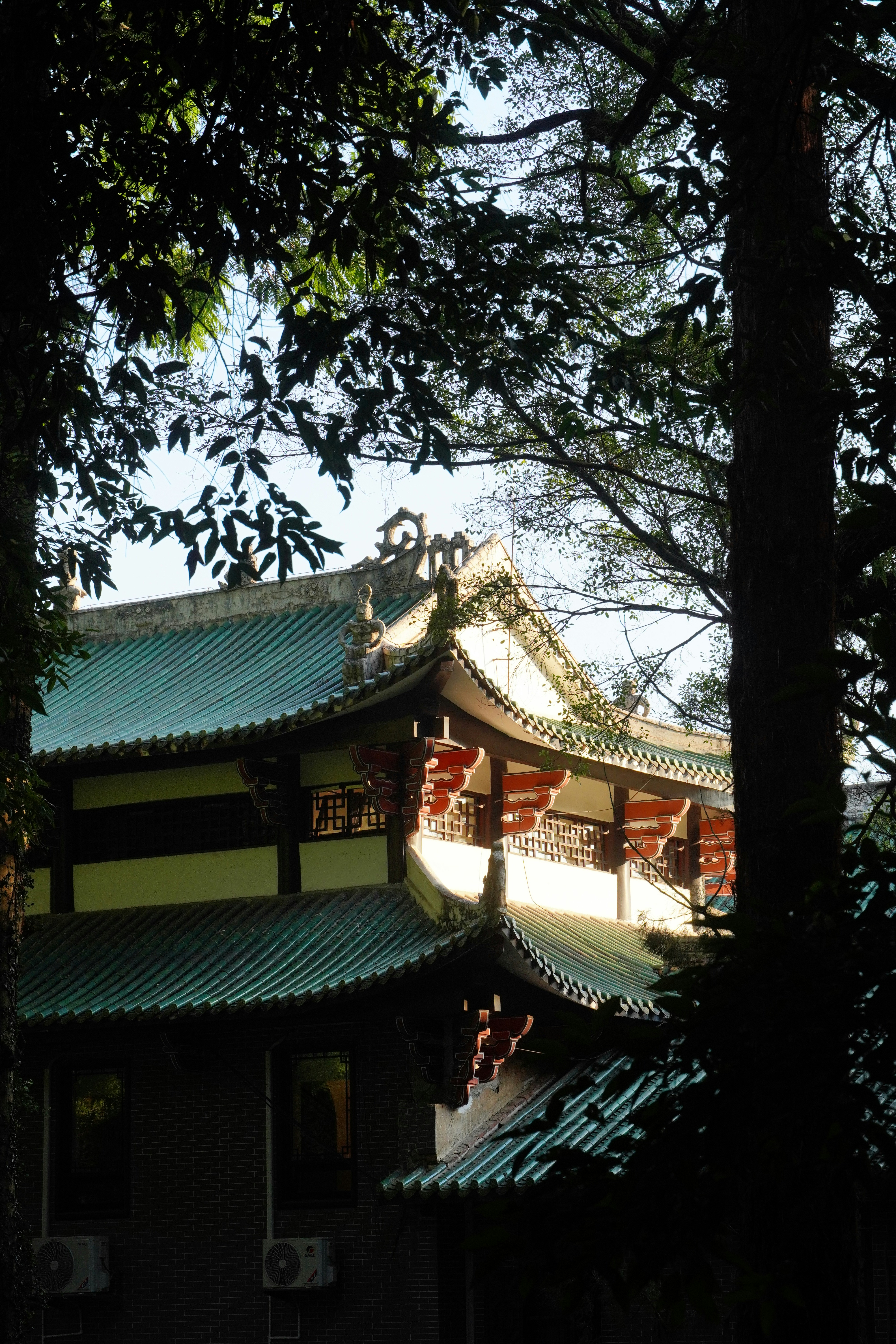 Sunlit pagoda roofs peeking through the forest canopy