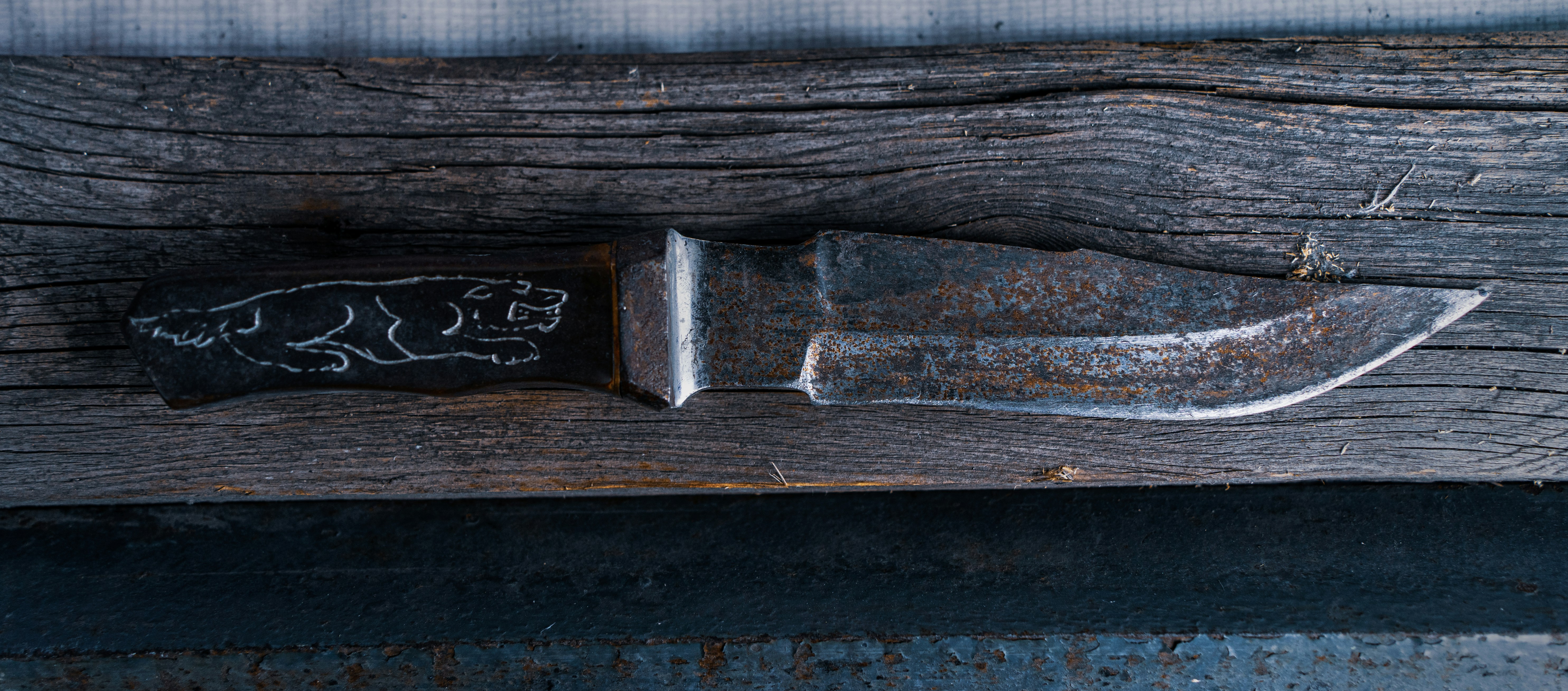 Worn Blade at Rest: A Weathered Knife Embedded in Time-worn Wood