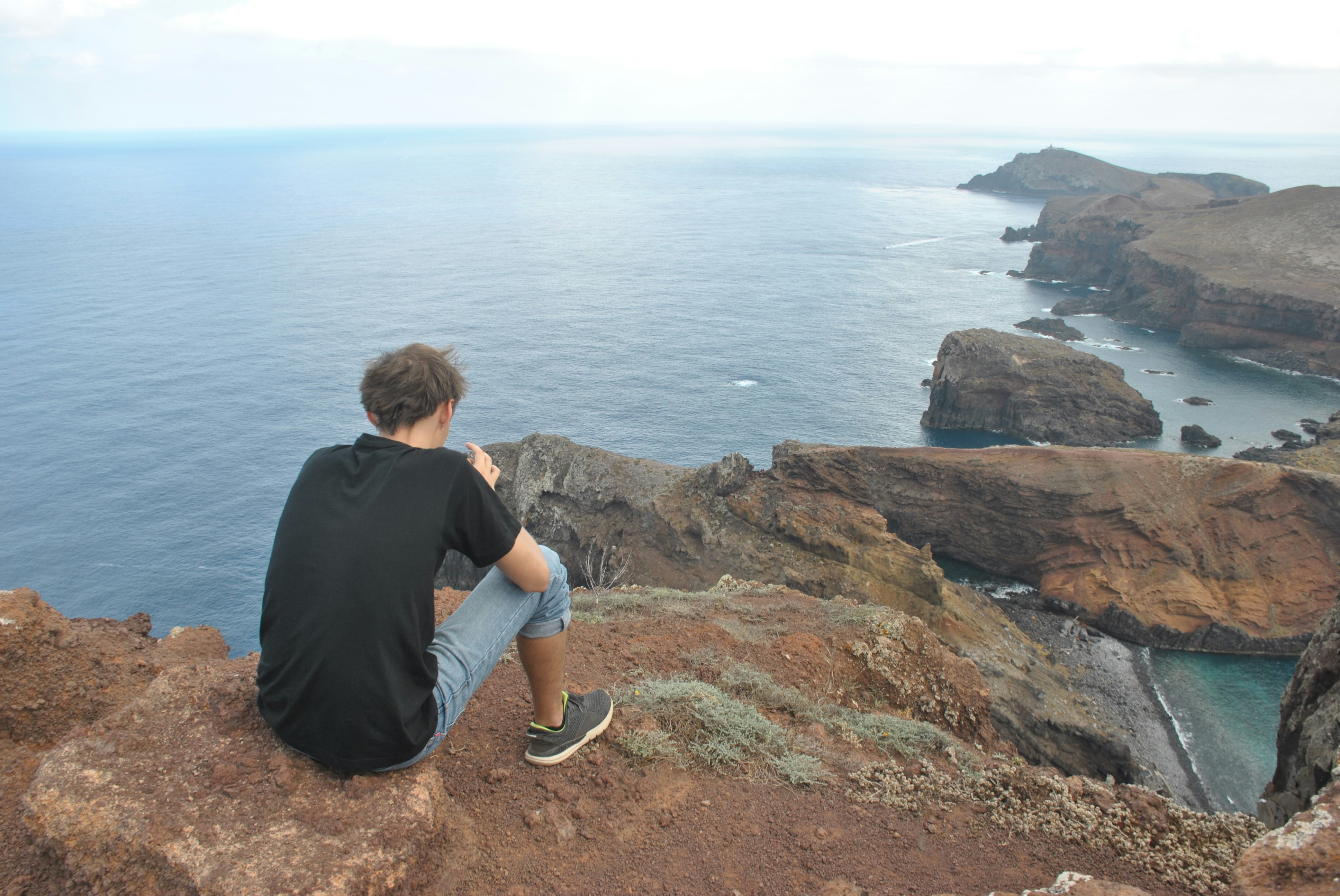 Edge of the World: A lone observer on rugged cliffs gazing toward the horizon