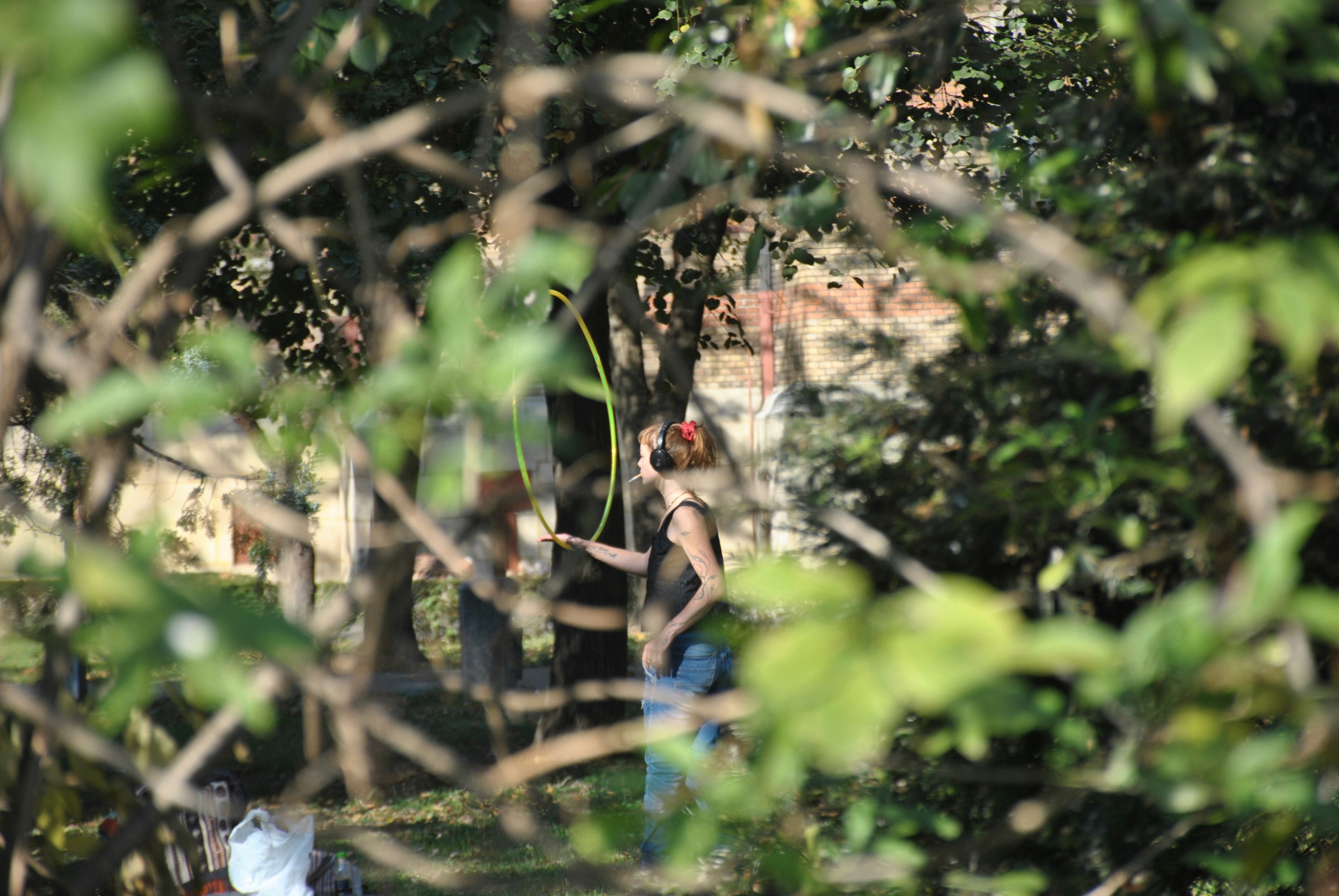 Muted Discovery: A Woman in a Garden Framed by Leaves