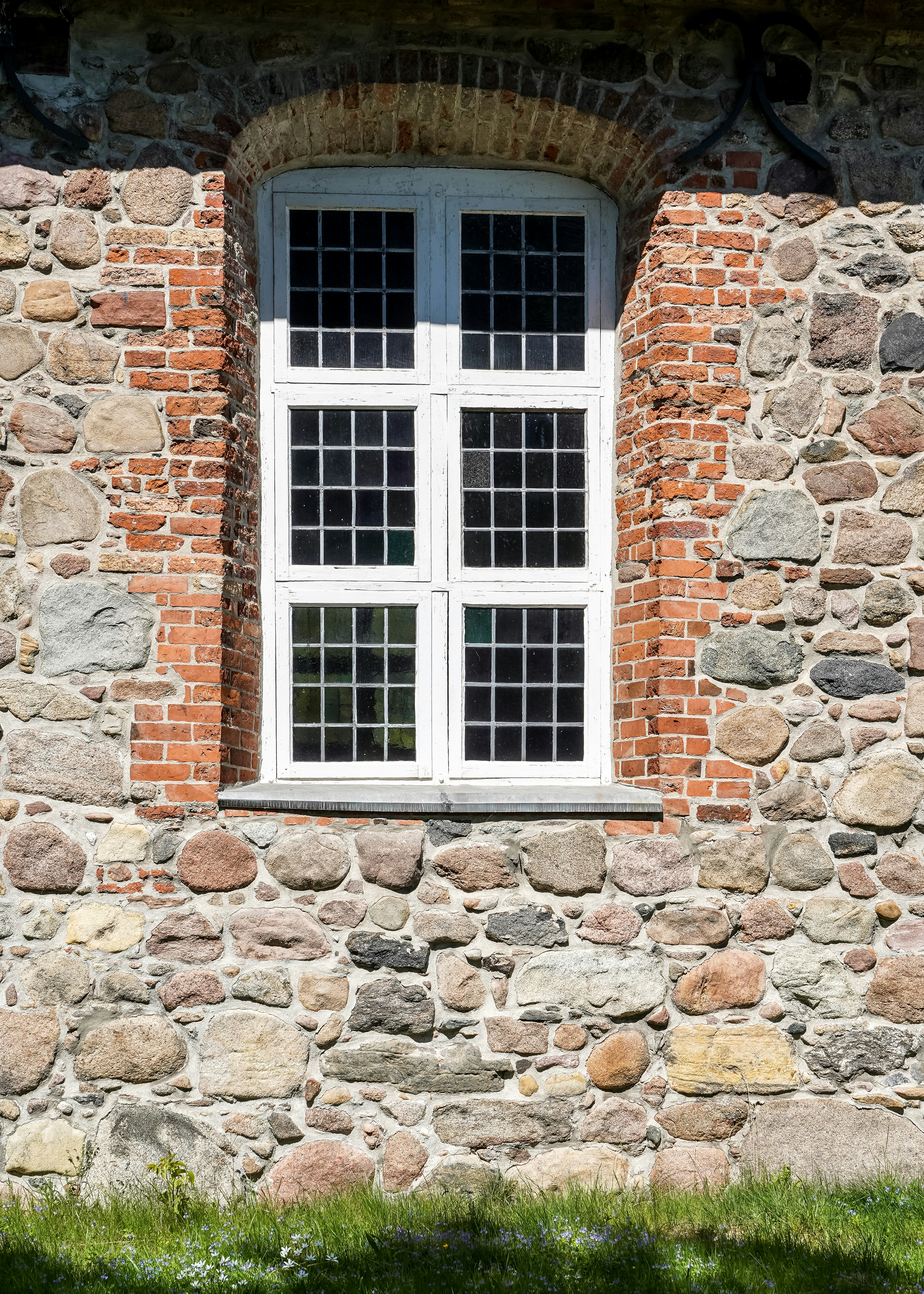 Stone Window in a Rustic Wall: Quiet Light Through Gridded Glass
