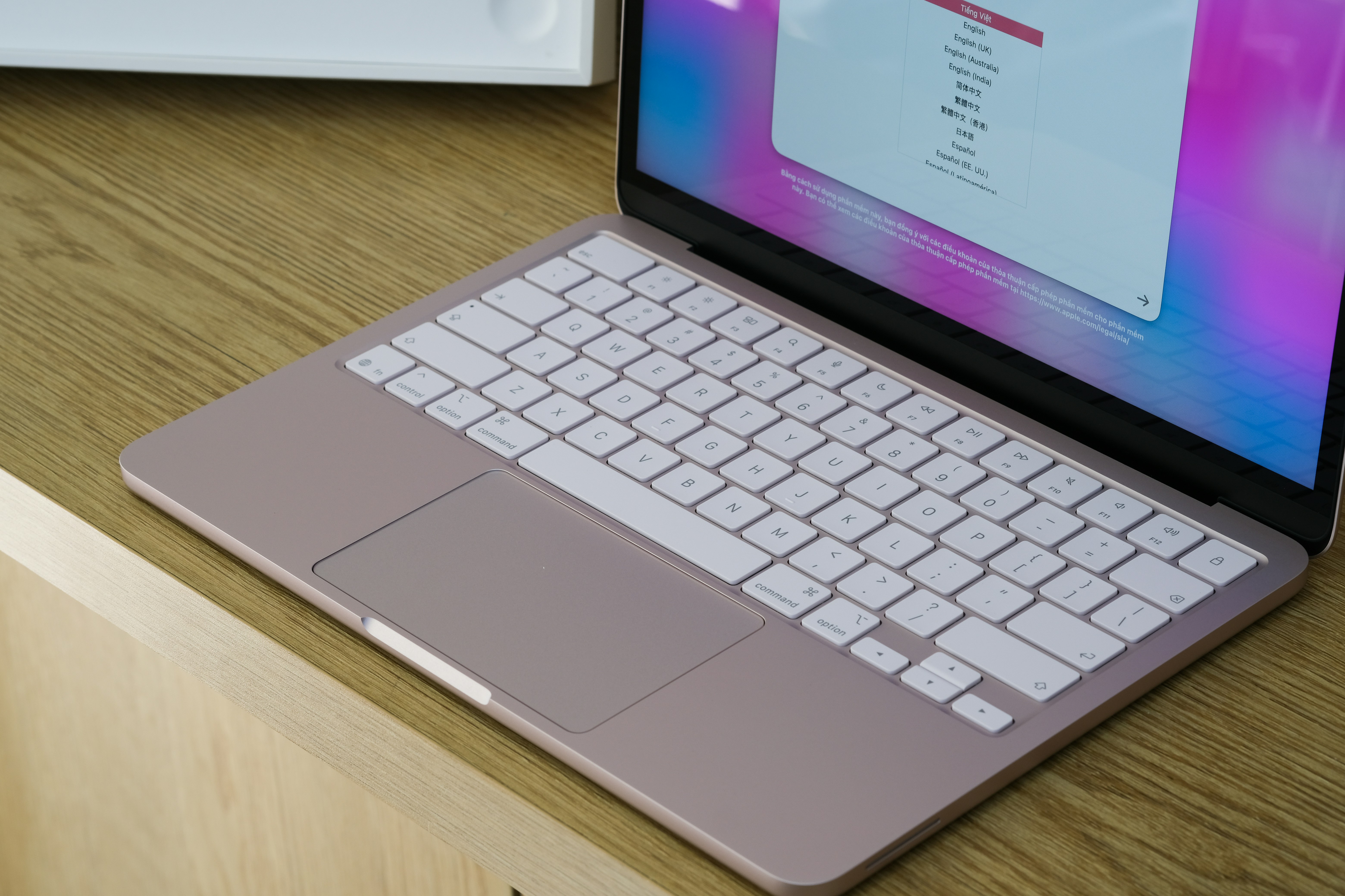 Rose Gold MacBook on a Wooden Desk with Soft Backlit Screen