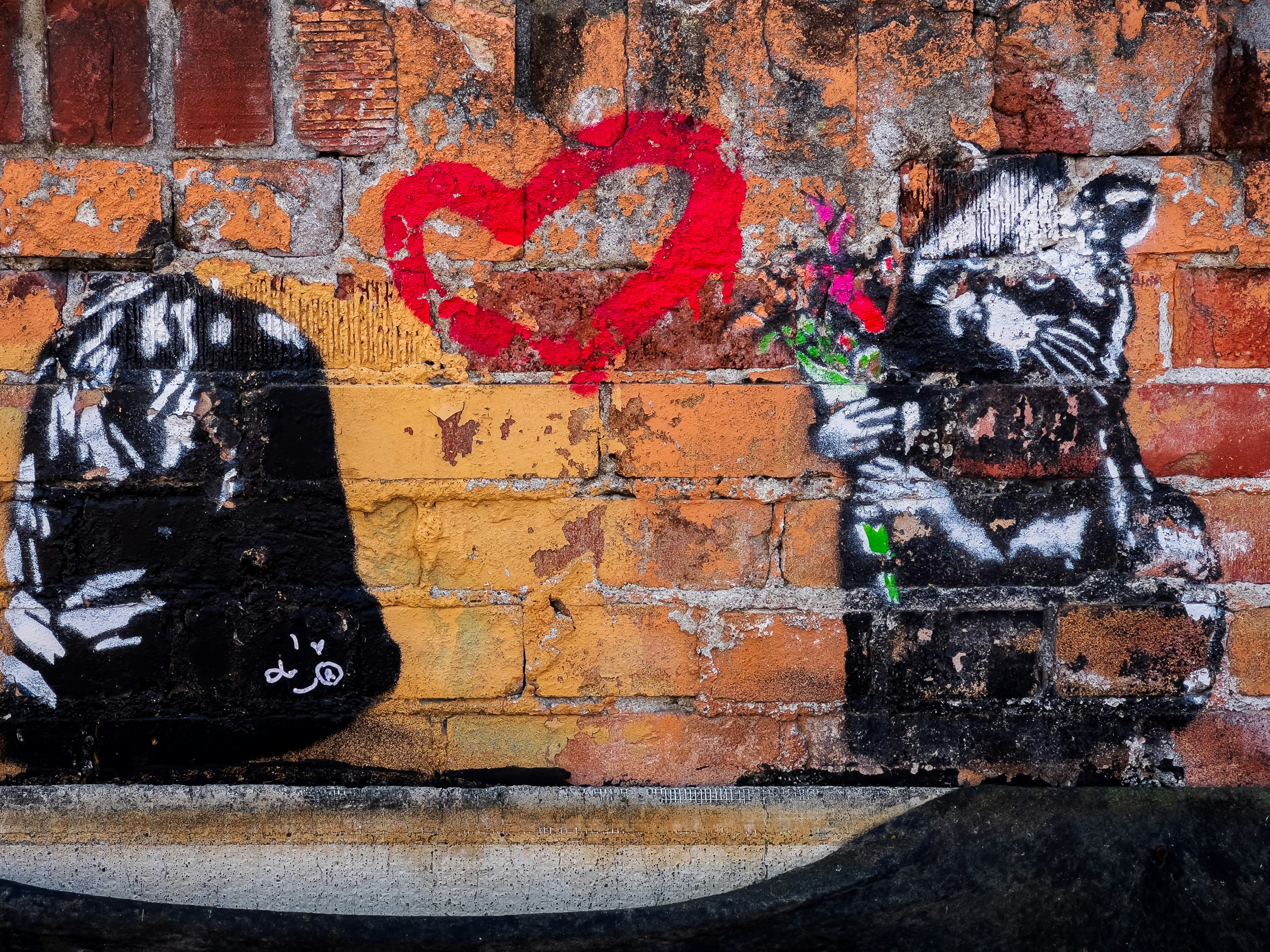 Two Cat Sprites Share a Heart in a Weathered Brick Scene