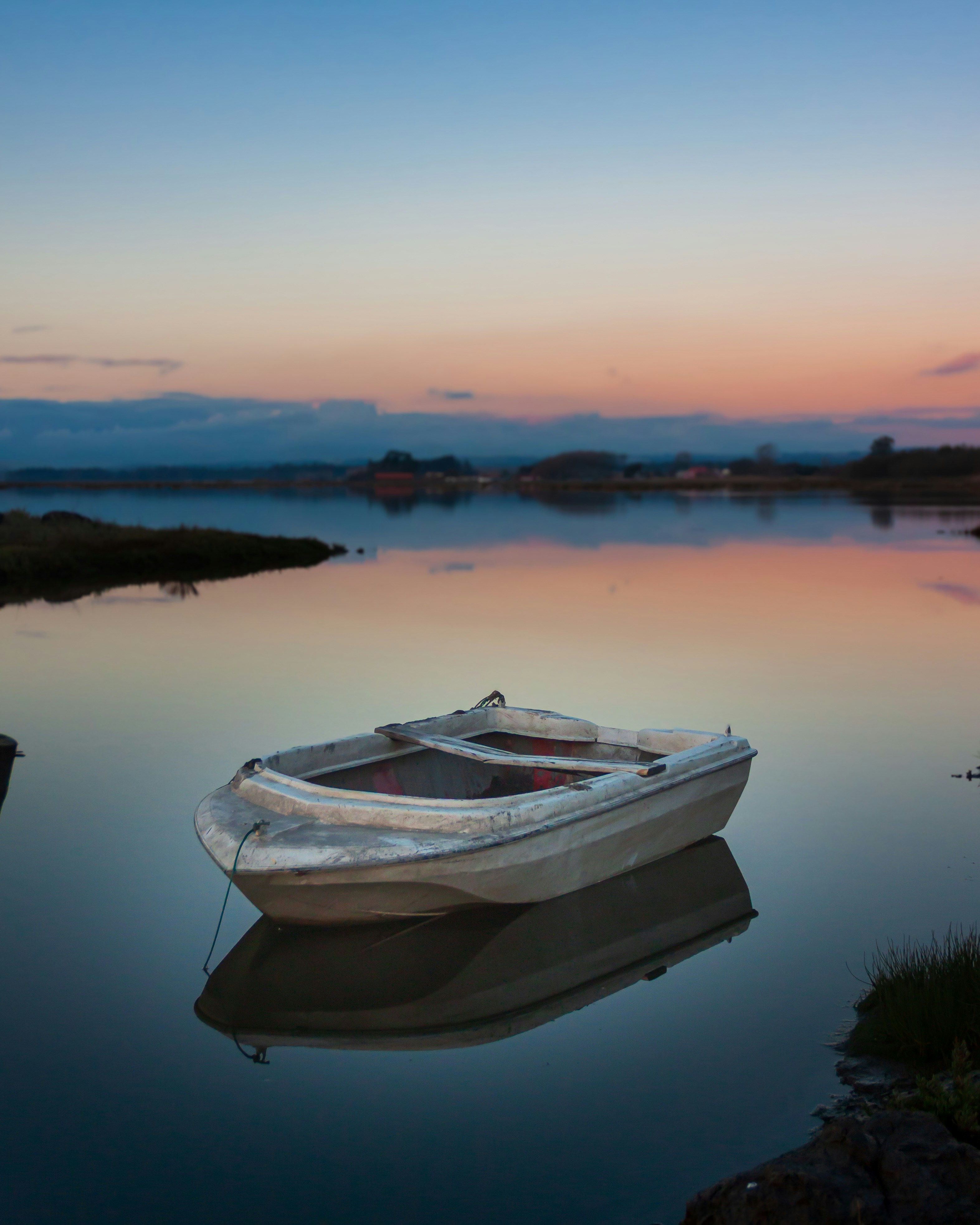 Boat at Dusk: A Quiet Mirror on Calm Waters