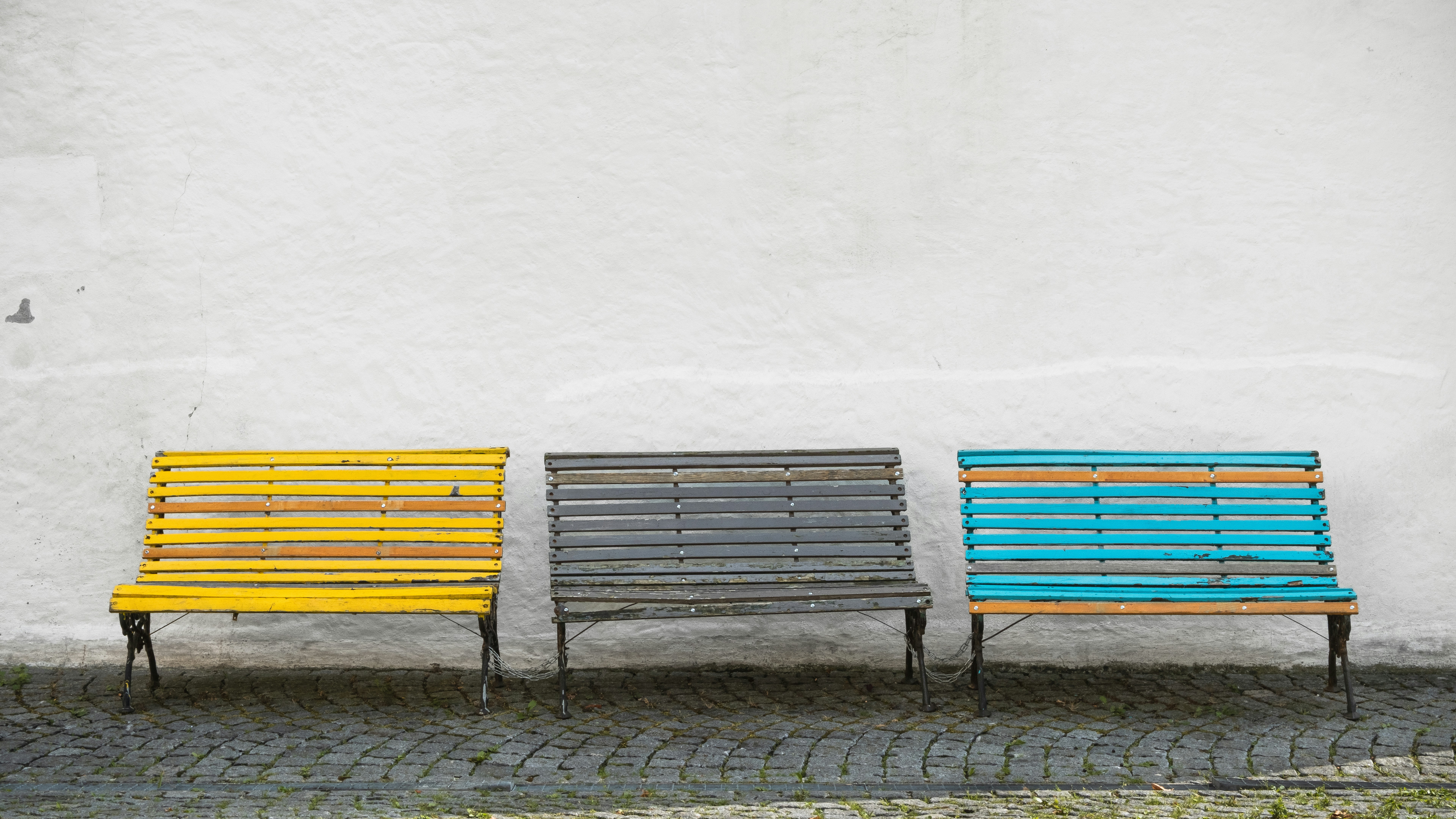 Three Painted Benches on a Cobblestone Threshold