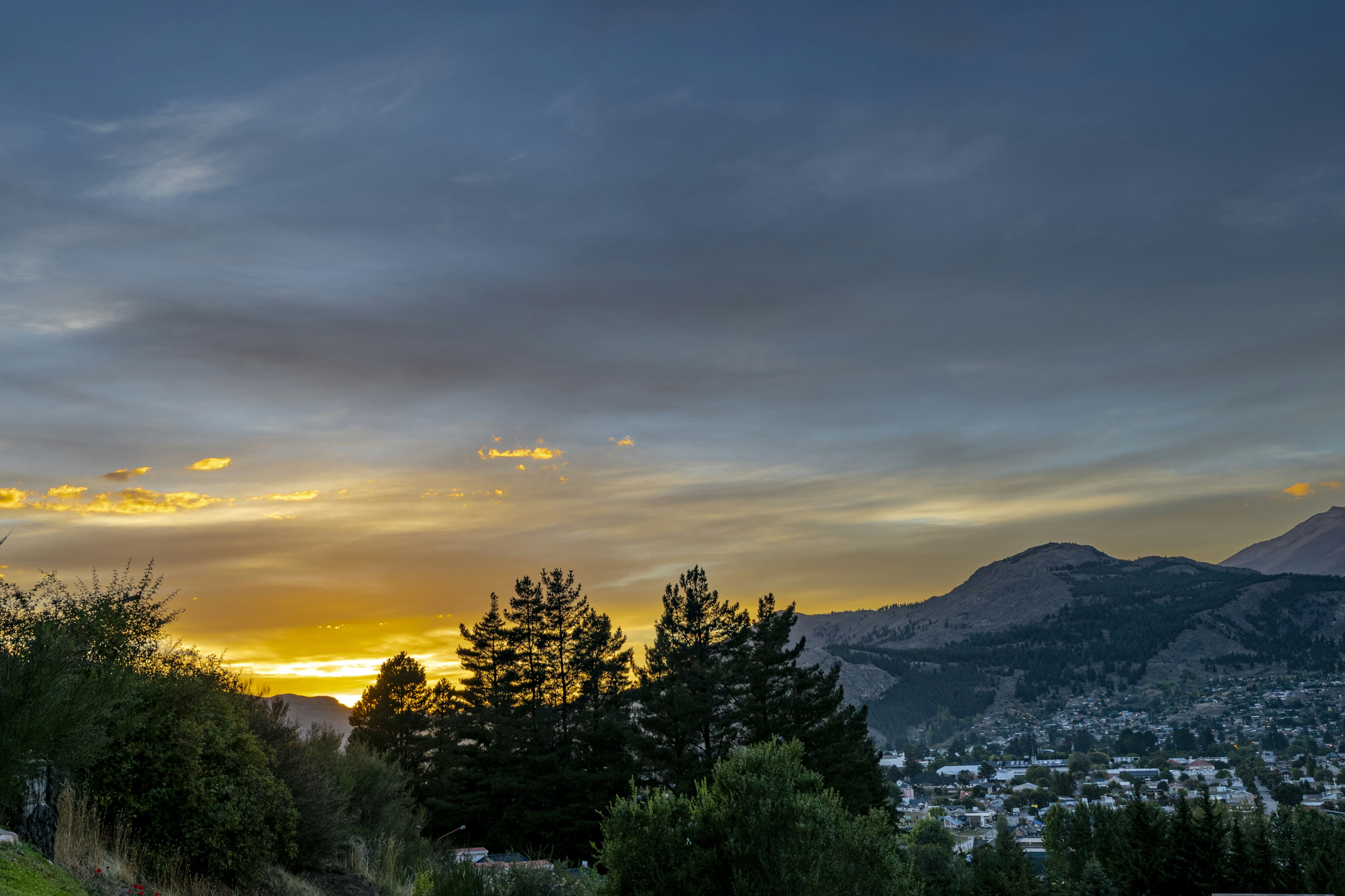 Sunset Over the Ridge: Conifer silhouettes and a Quiet Town