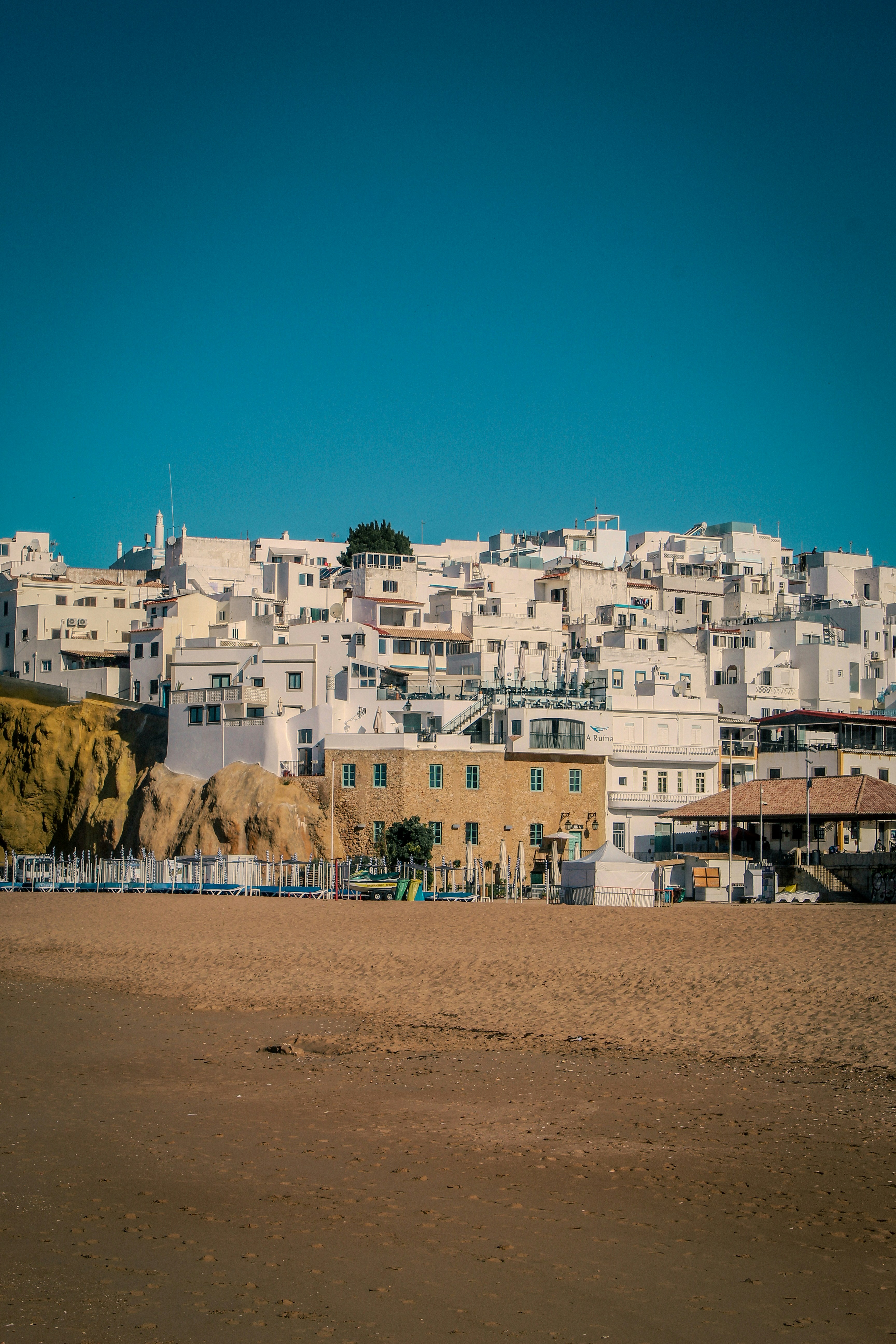 Whitewashed Village Rising Above the Golden Beach