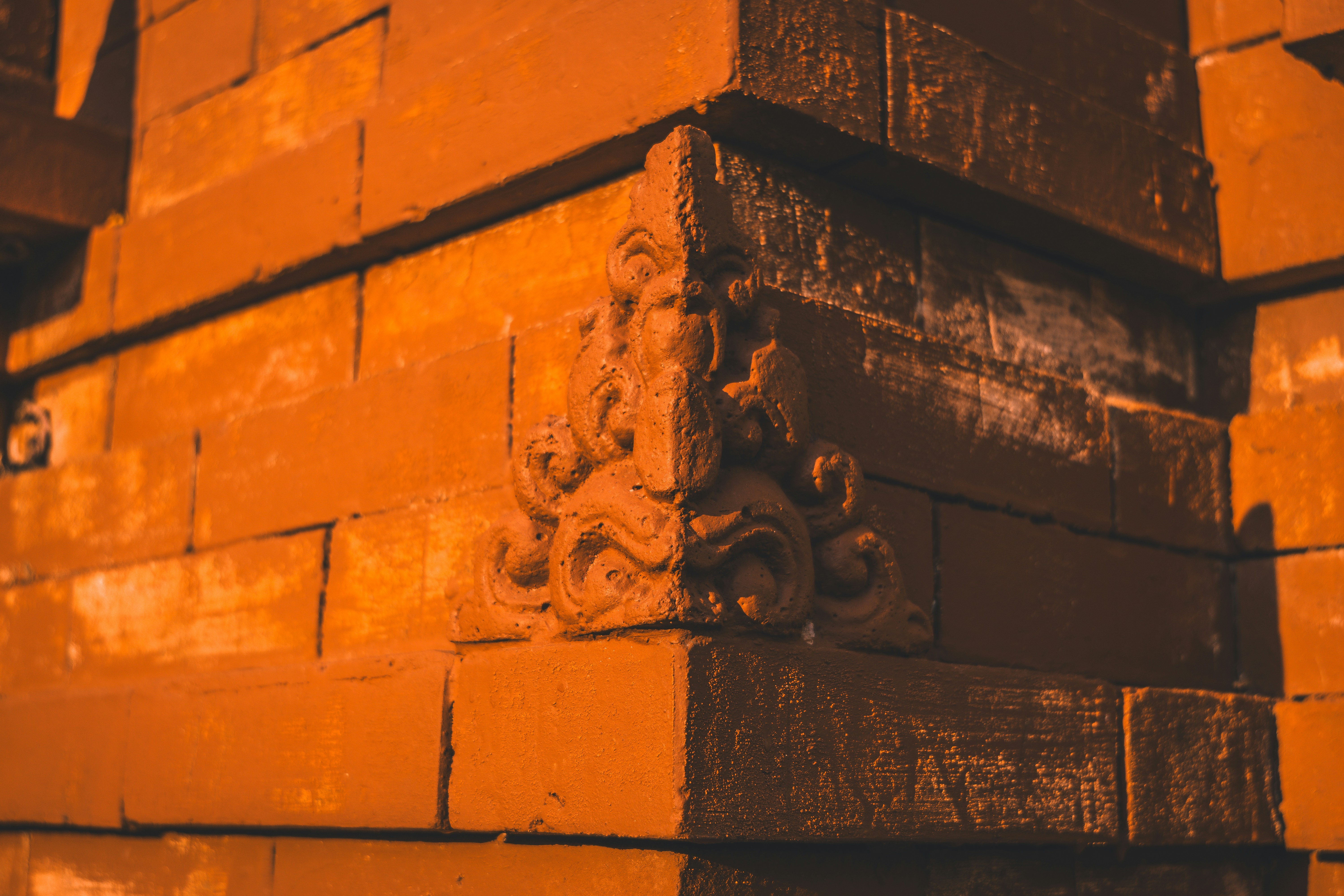 Ornate Corner: Carved Stone Beneath a Warm, Amber Veil