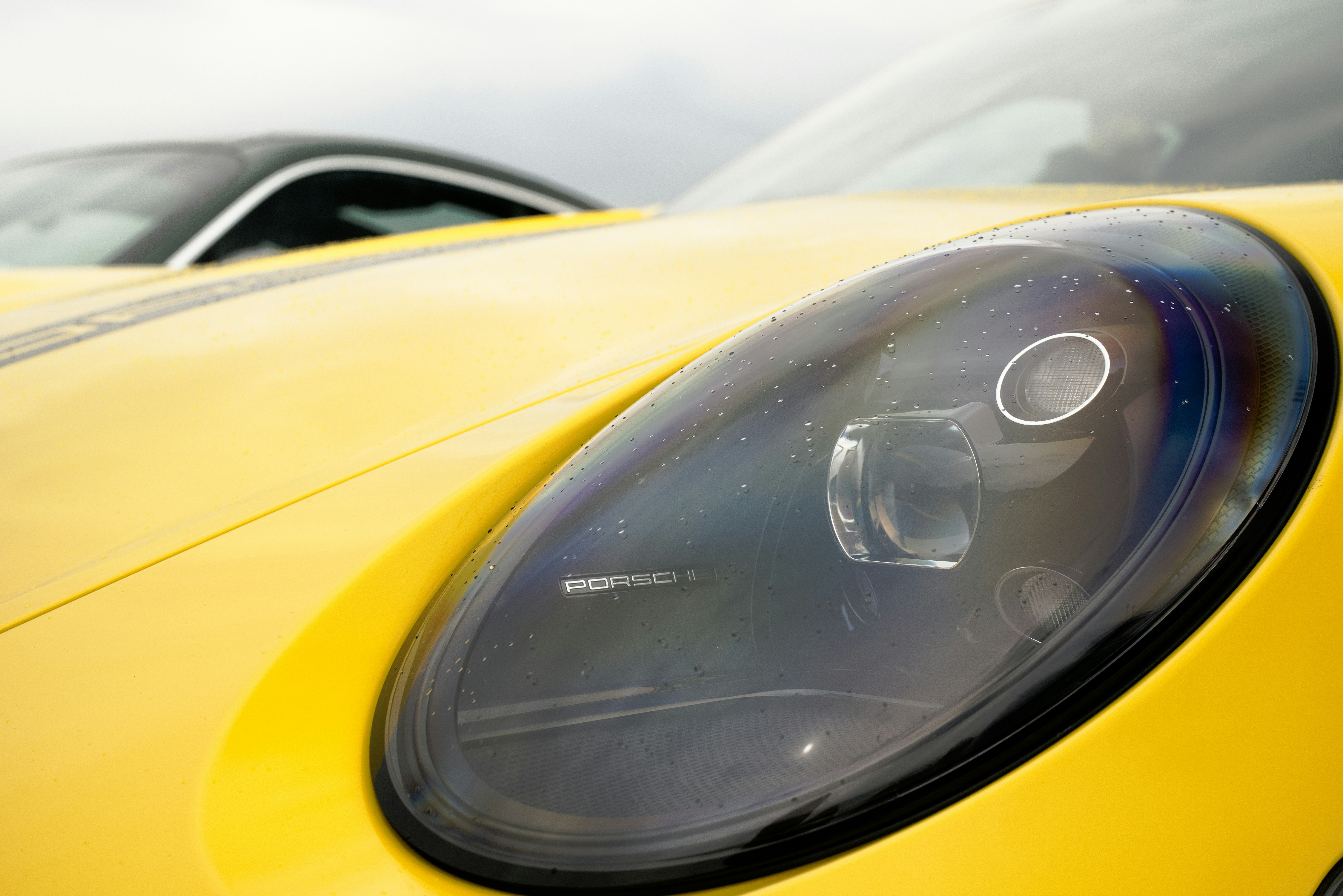 Yellow Chevron: A Close-Up of a Porsche Headlamp in Motion Blur