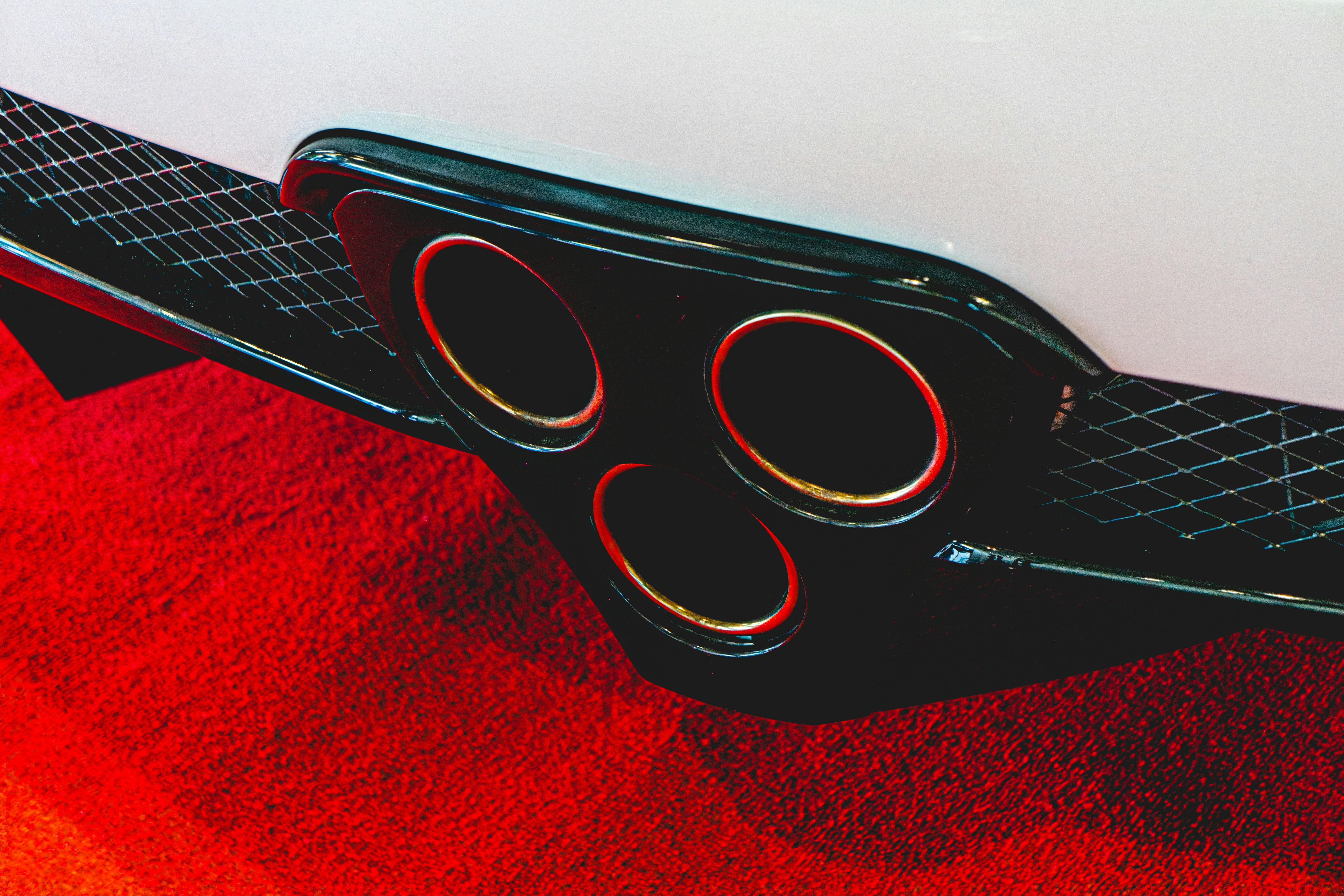 Chrome Echo: Quad Exhaust Rings Against Scarlet Carpet