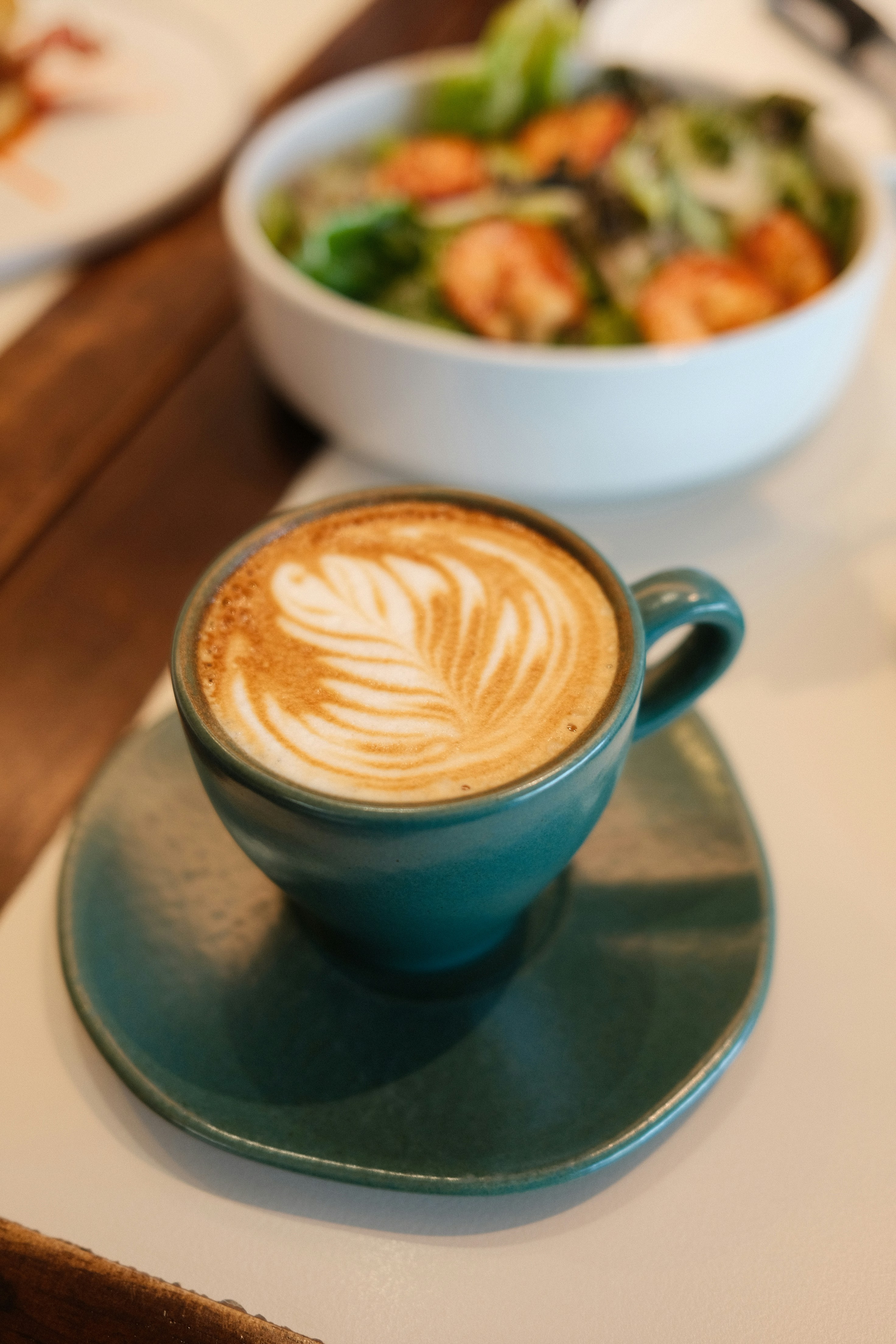 Cup of Foam and Faraway Salad: A Café Moment in Soft Focus