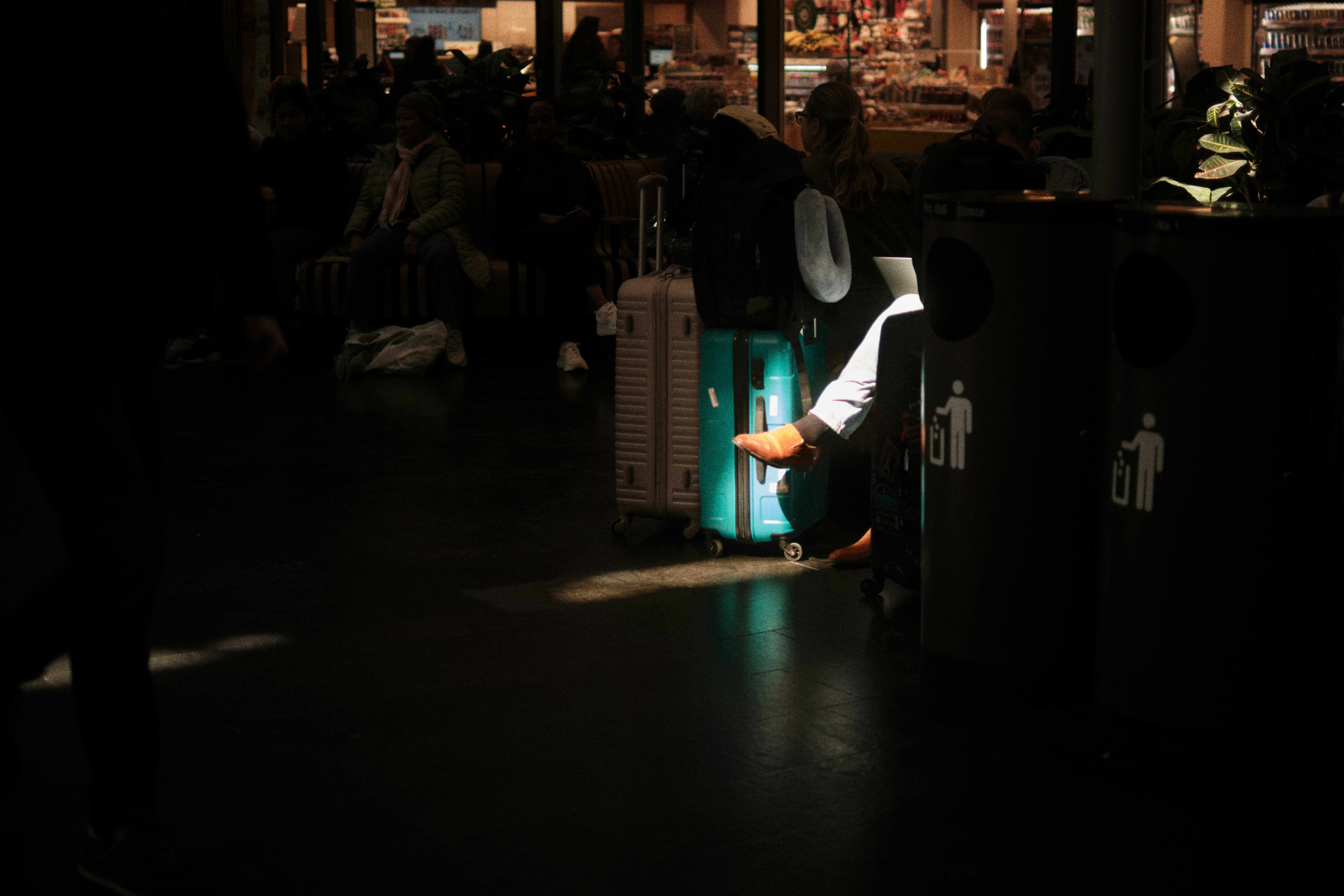 Person throwing trash into bin at night