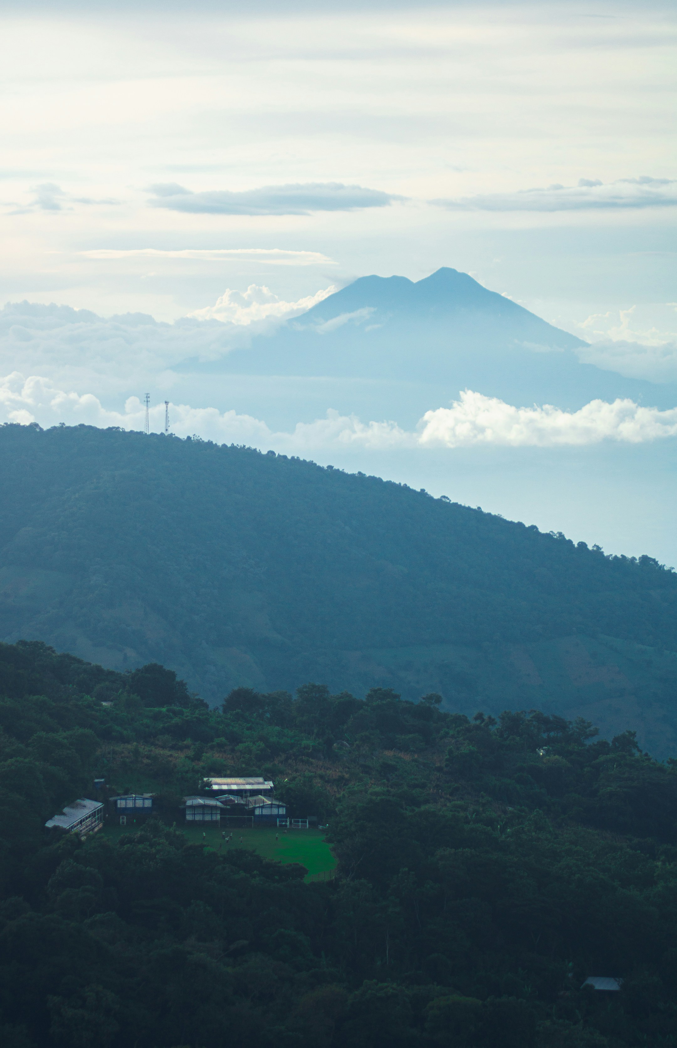 Peaceful Summit: A Layers of Hills Beneath a Misty Peak