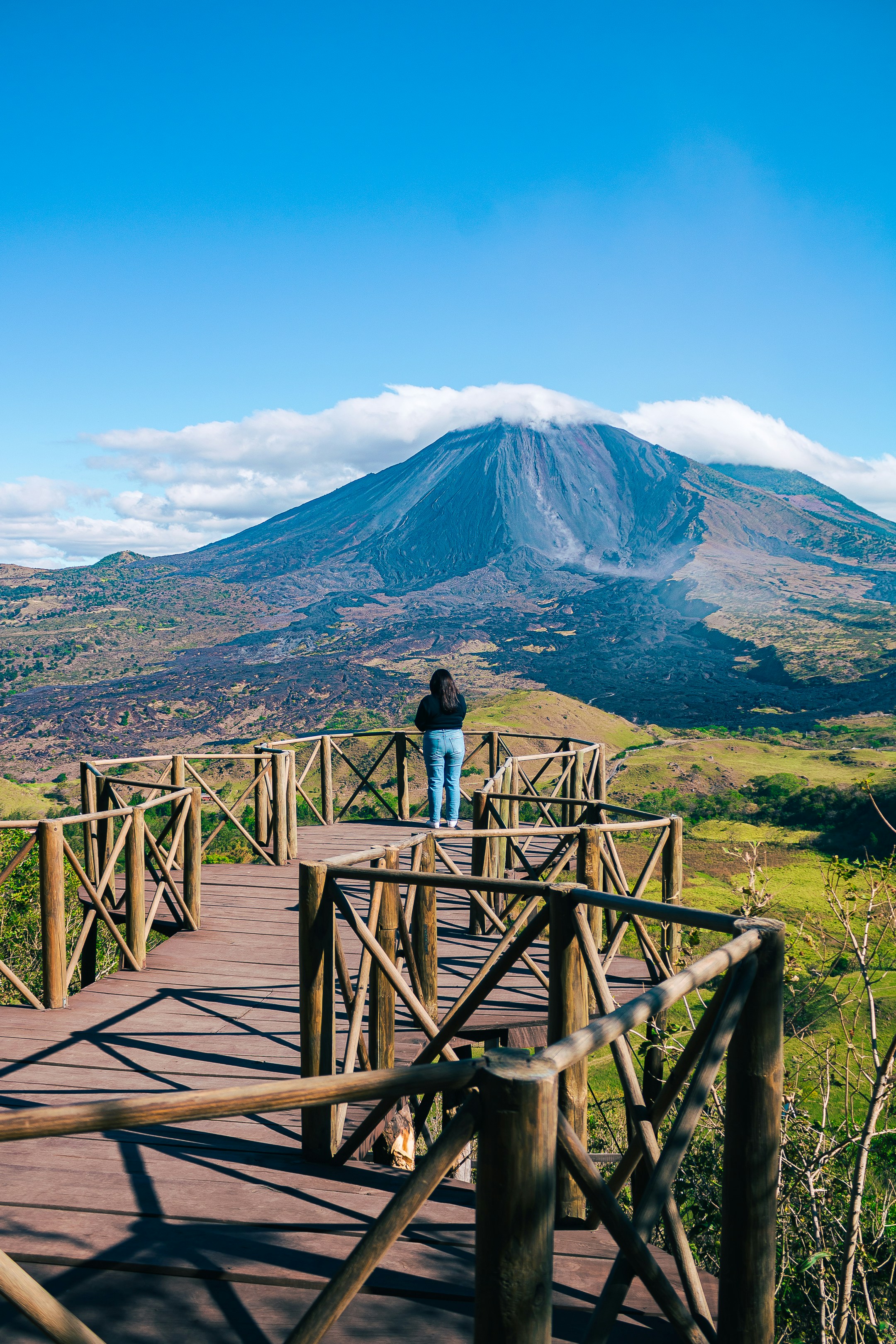 Floating Amidst a volcanic panorama: a lone observer on a wooden walkway