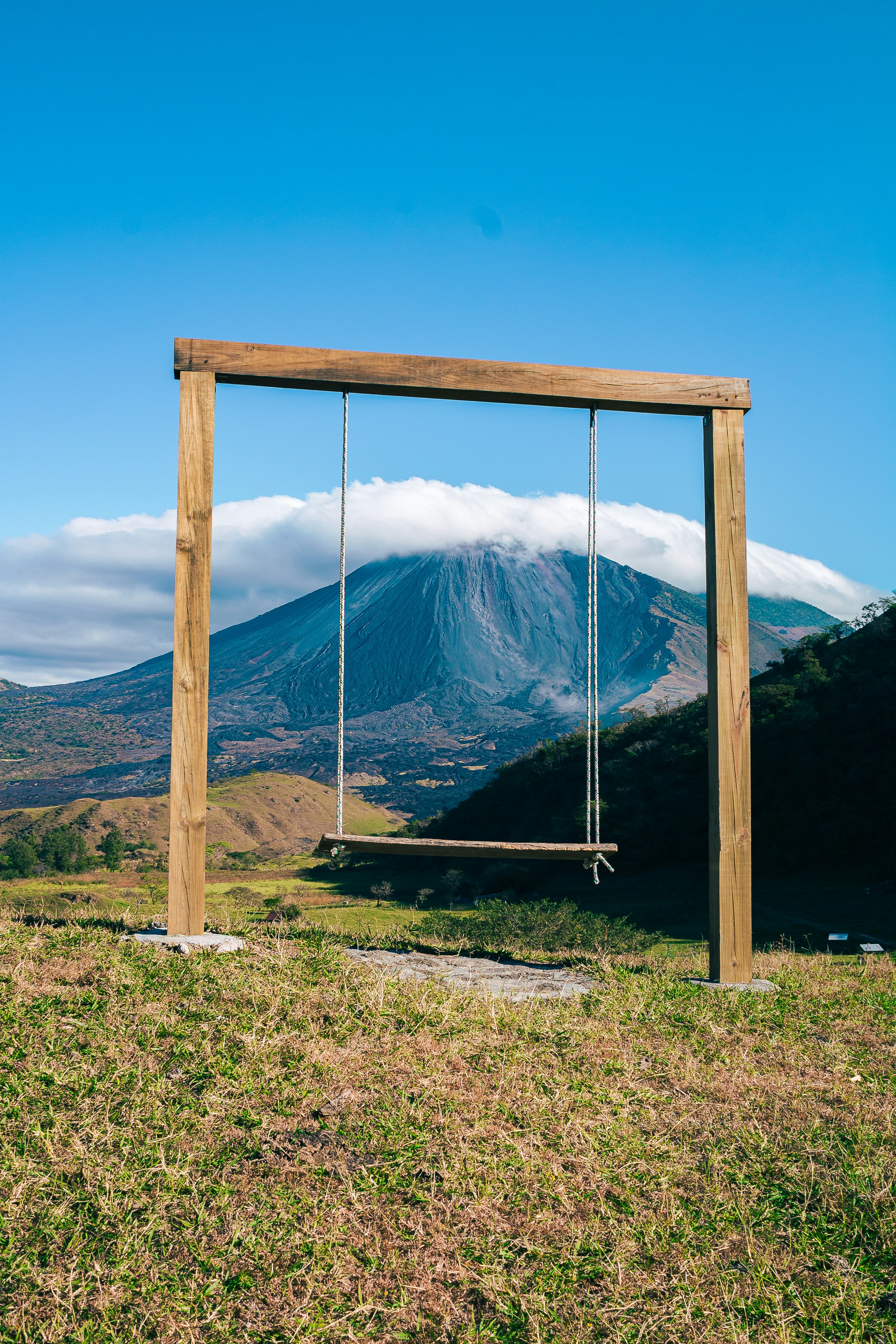 Wooden Swingframe Framing a Volcano: A Quiet Moment in the Valley