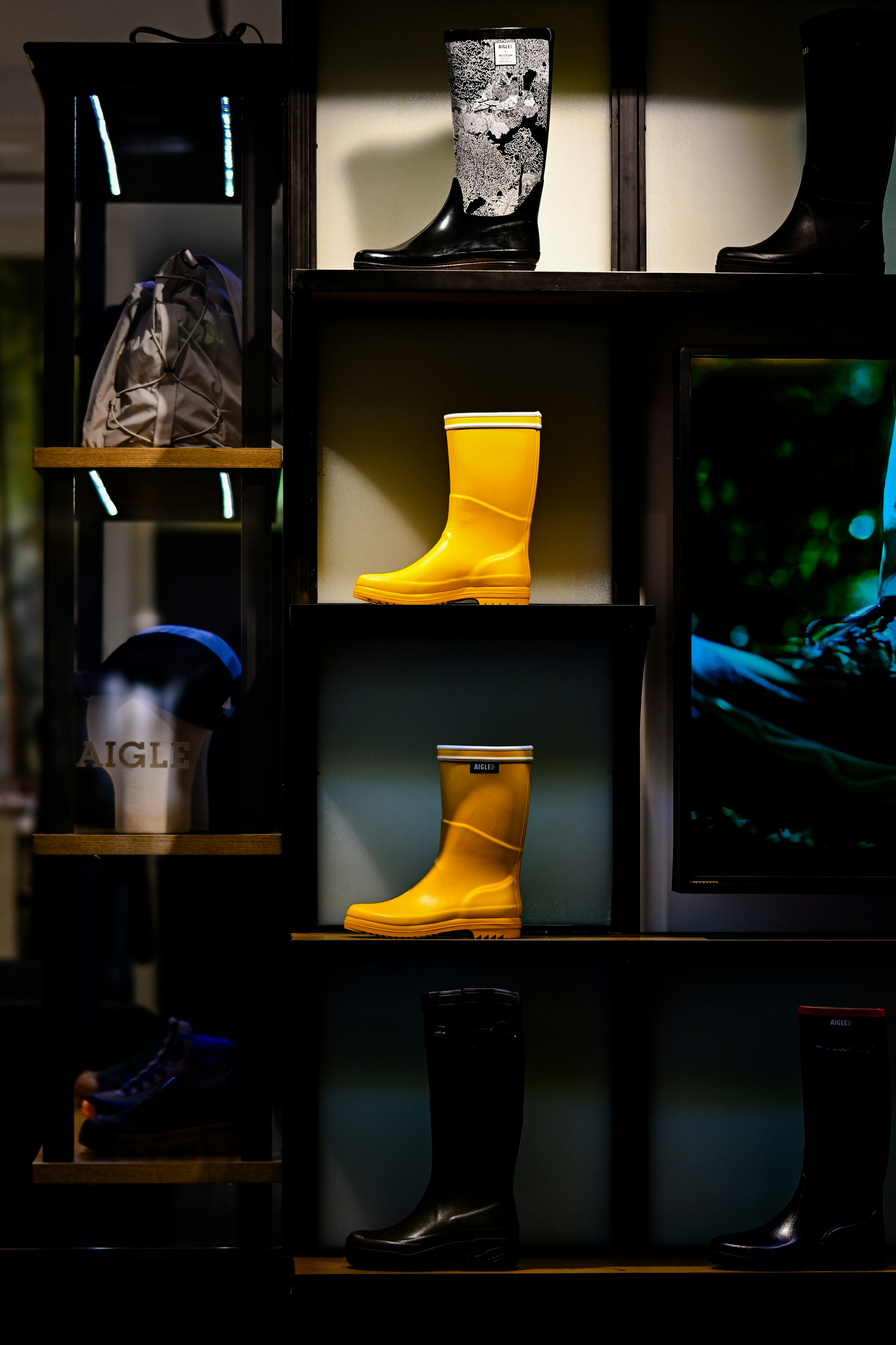 Bright Yellow Boots Take Center Stage on a Shadowed Display Wall