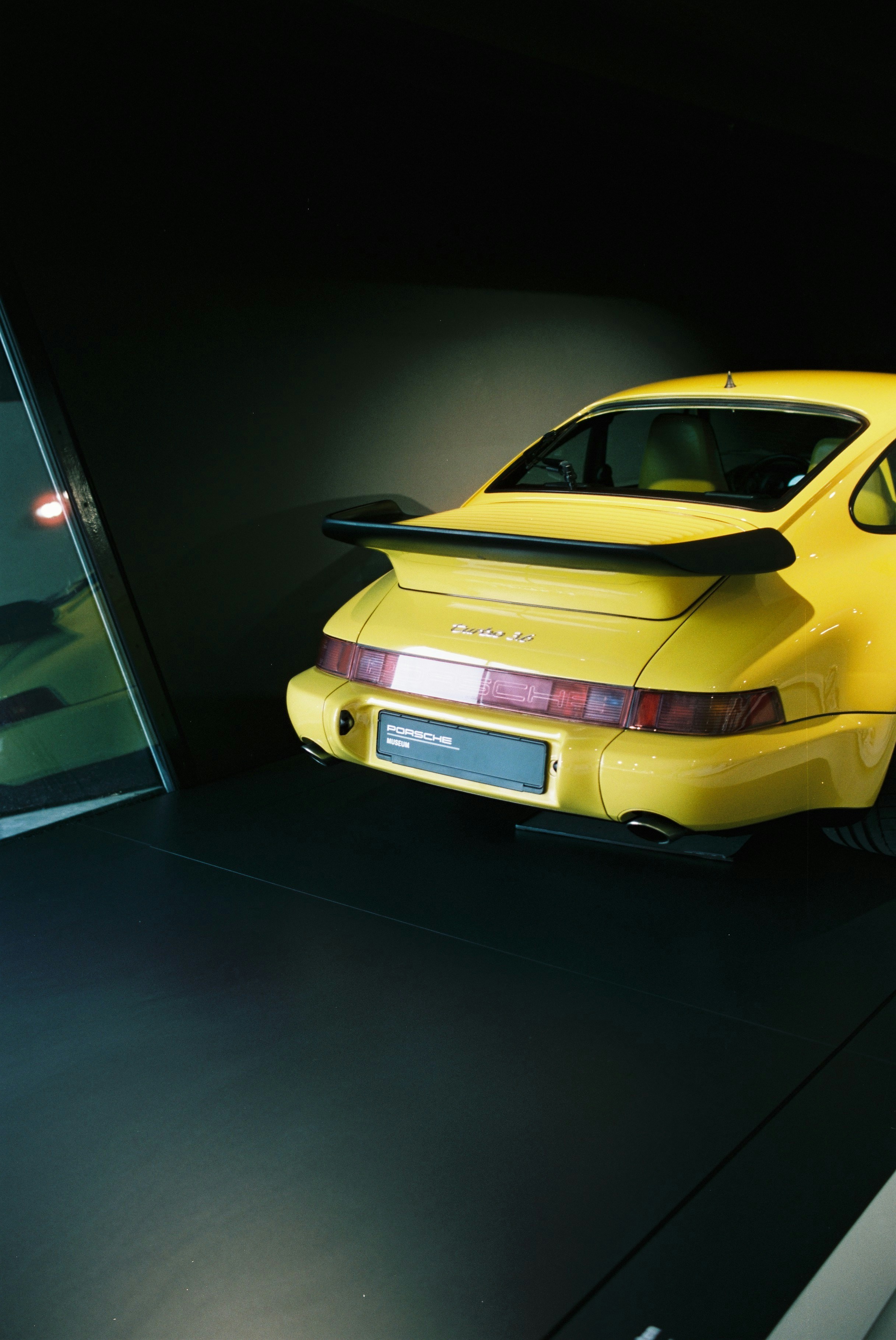 A yellow porsche sports car with a large spoiler.