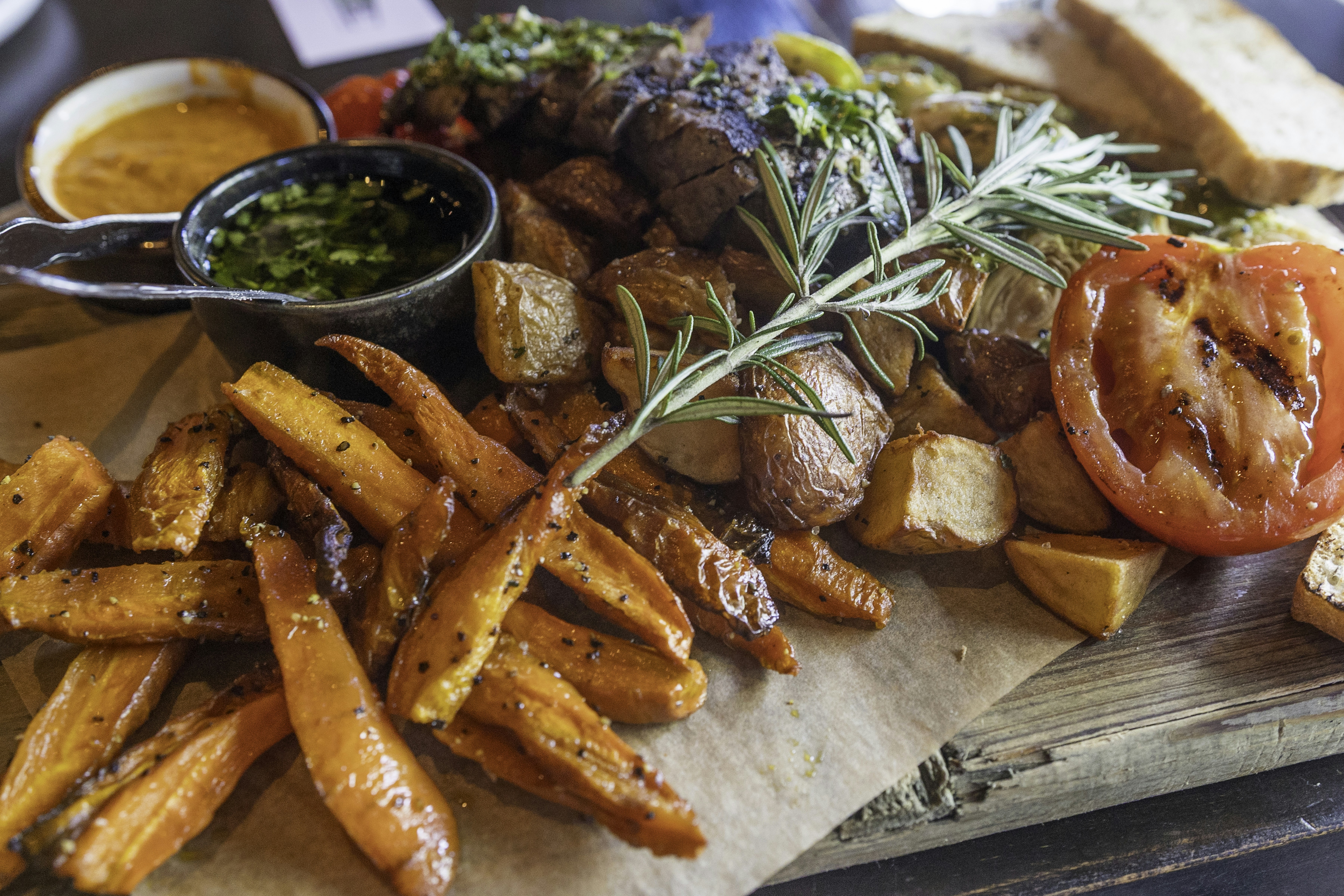 Rosemary Steak with Roasted Potatoes and Caramelized Tomatoes on Board