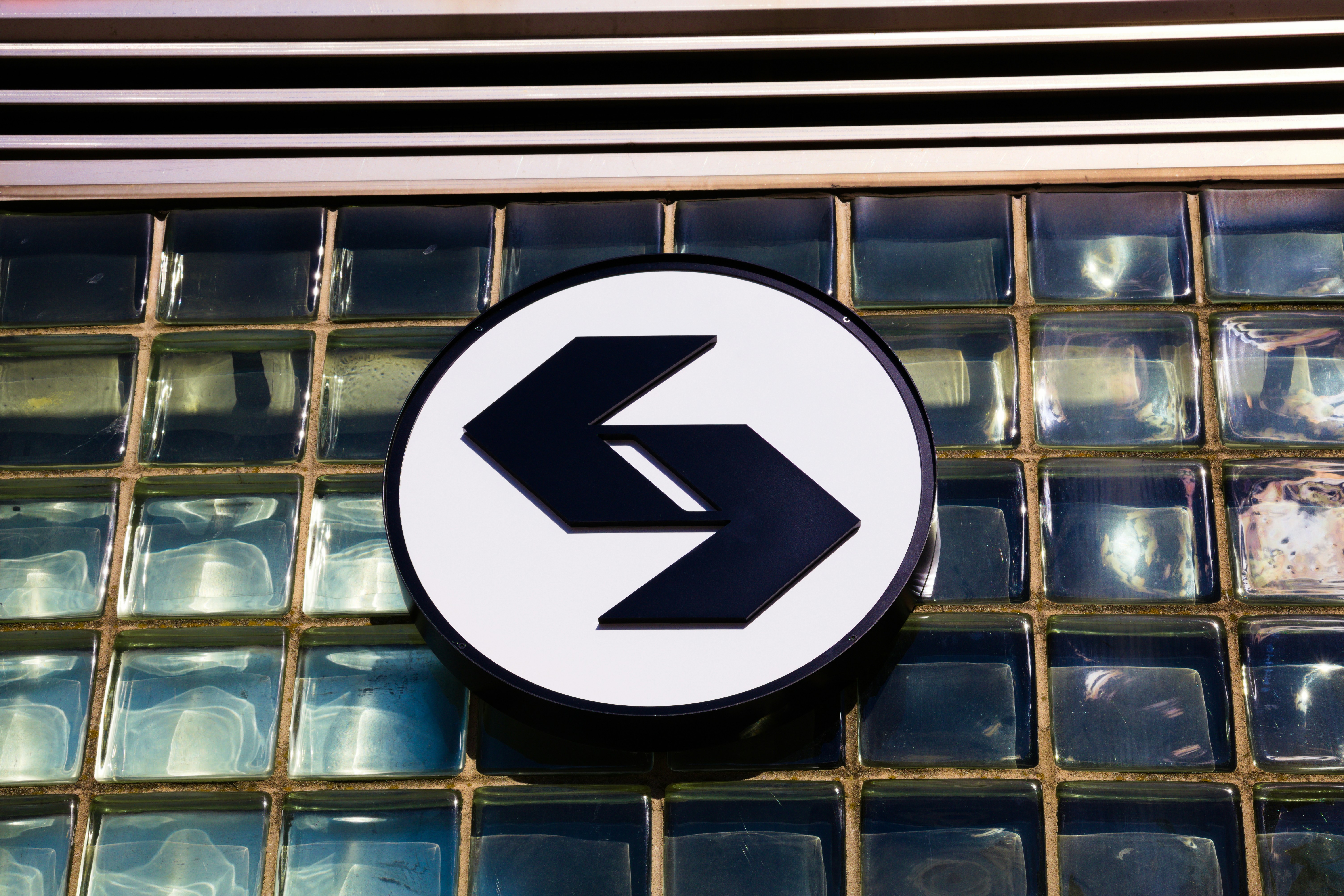 Signet in Glass: A Modern Emblem on Tiled Facade