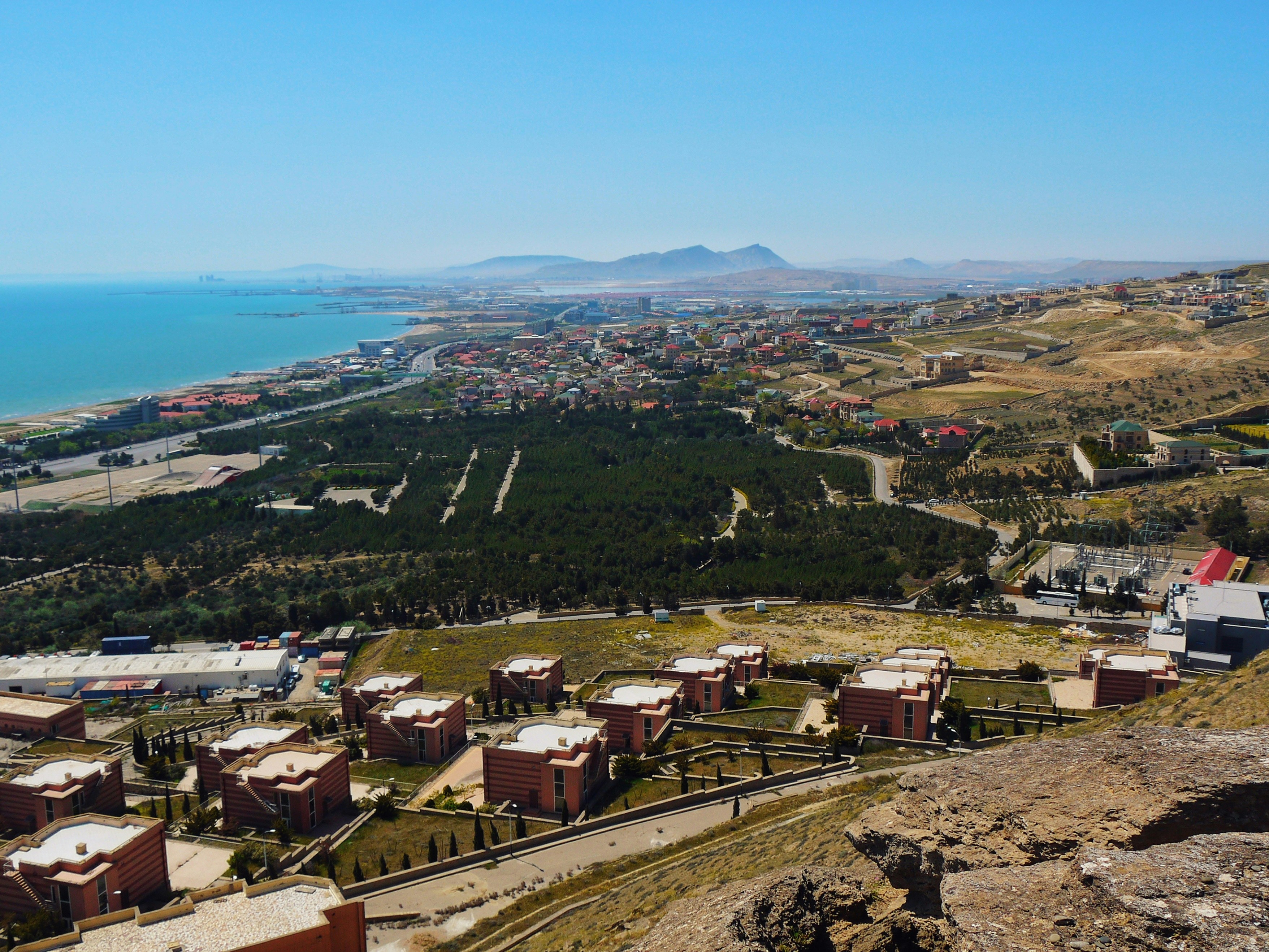 Coastal hillside village unfurls toward a calm sea