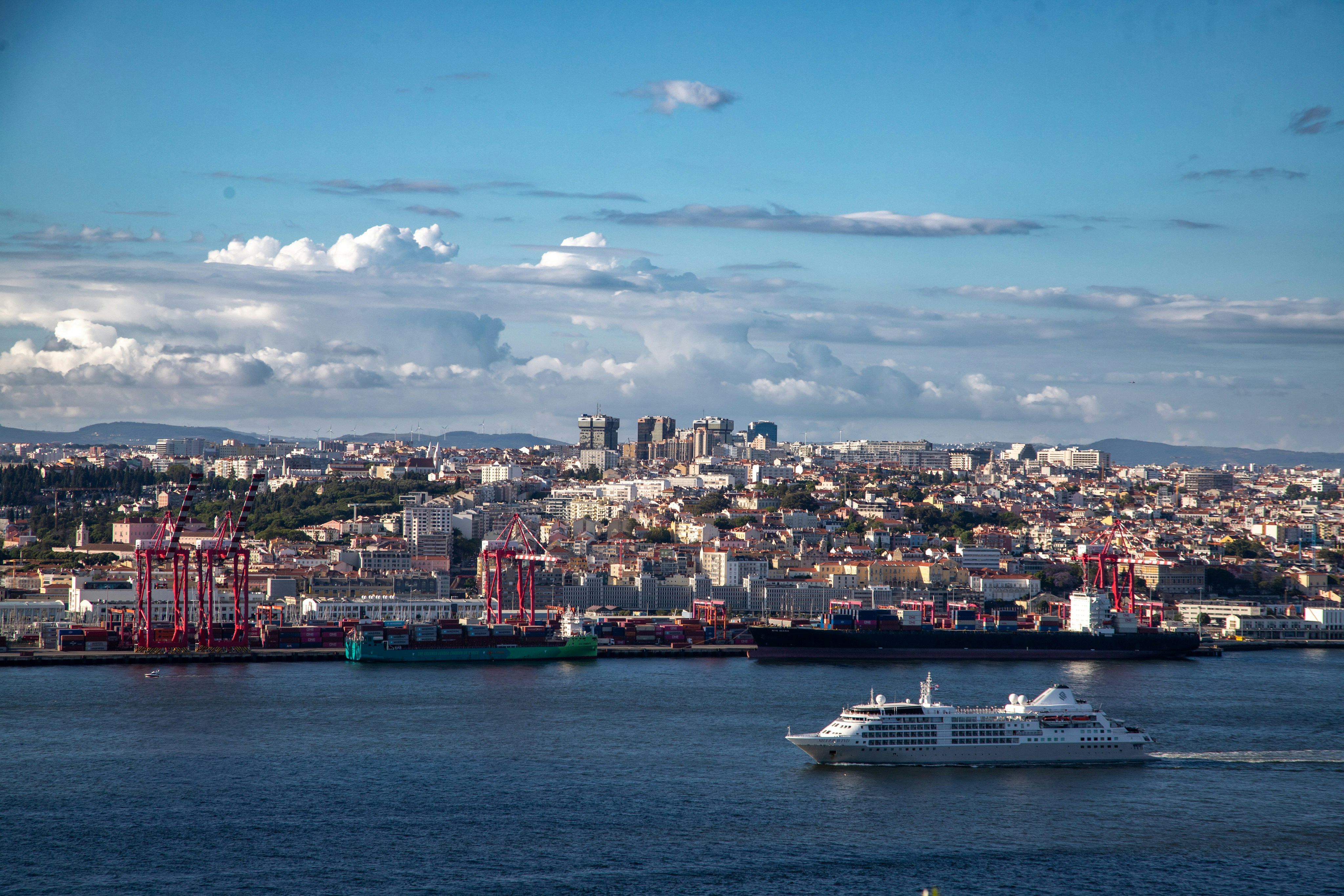 Harbor Vista: City Skyline and White Cruise Against a Calm Sea