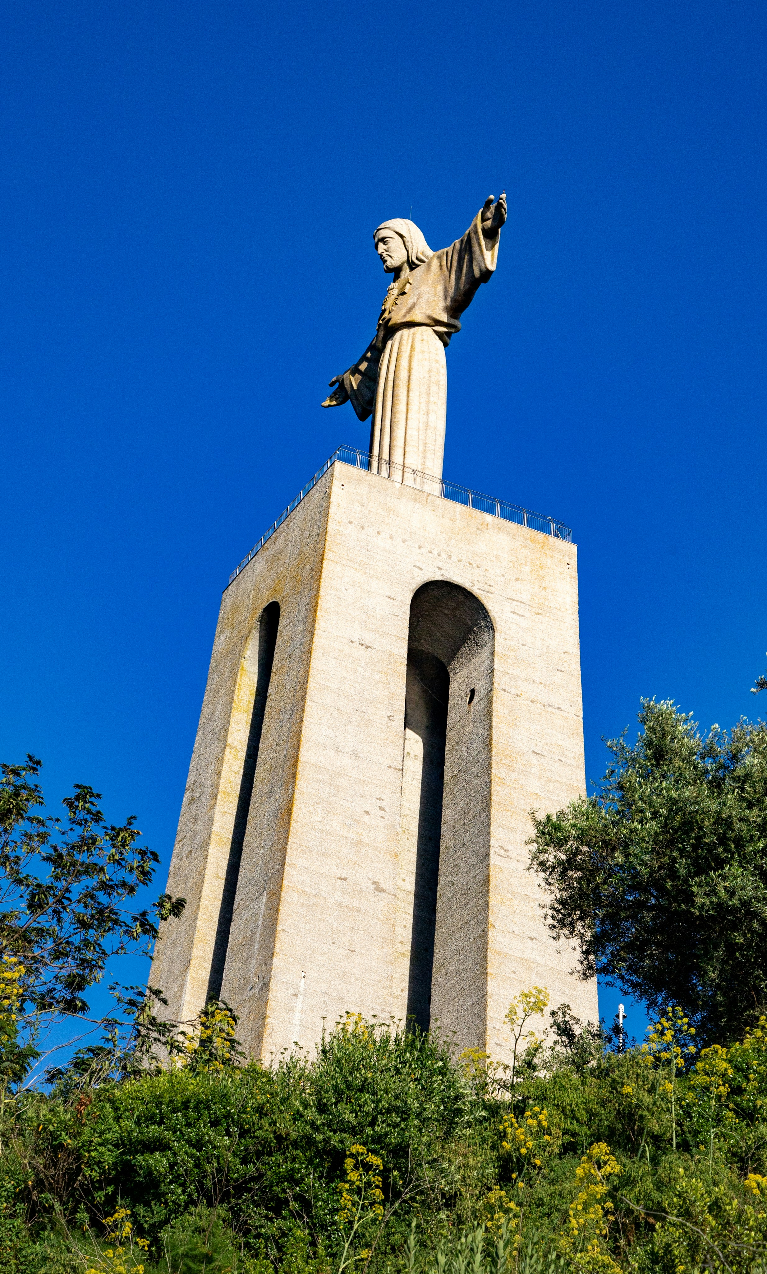 Rising Figure: Prophet statue crowns a limestone column under a cobalt sky