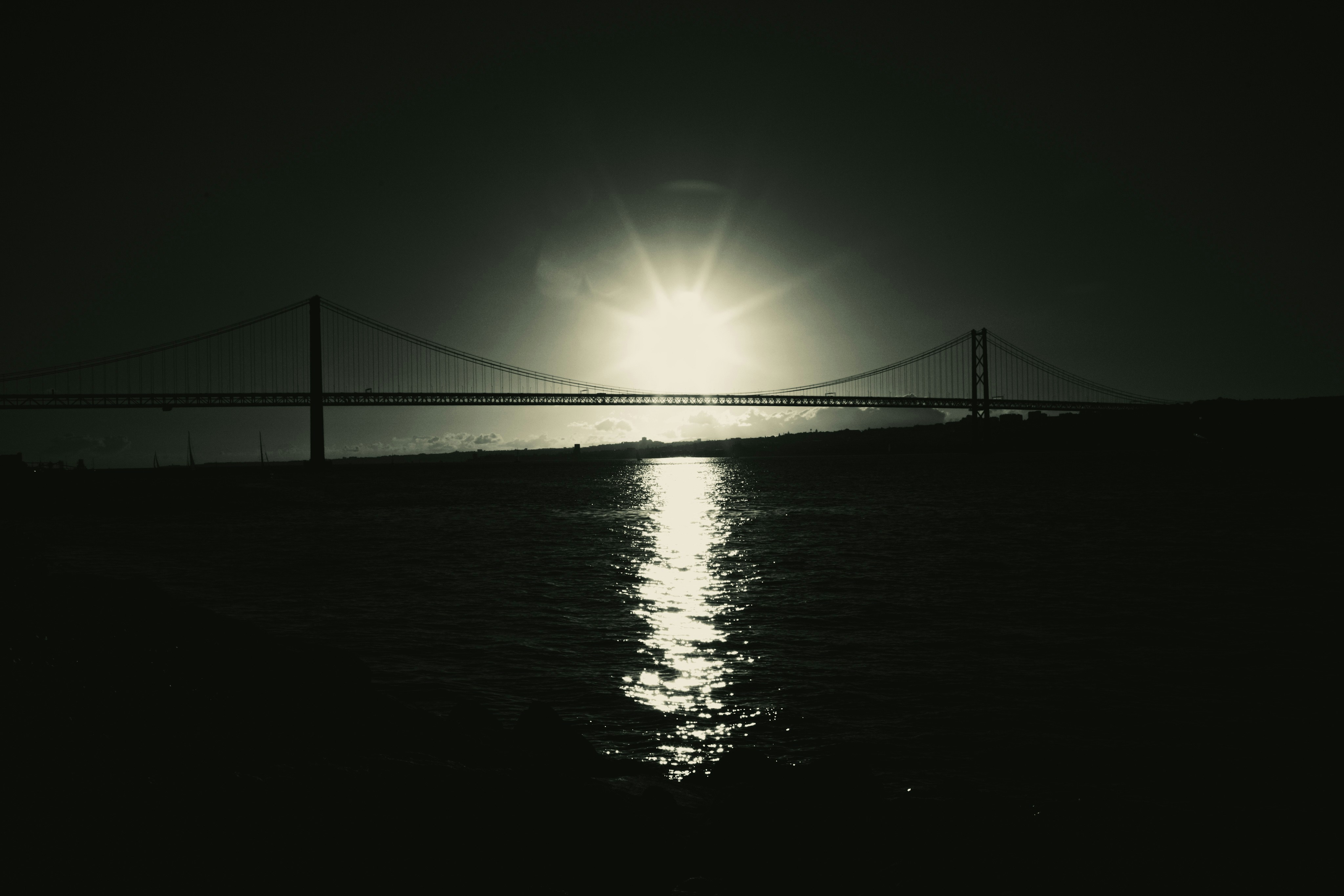 Sunlit silhouette: a quiet bridge crossing a reflective river at dusk