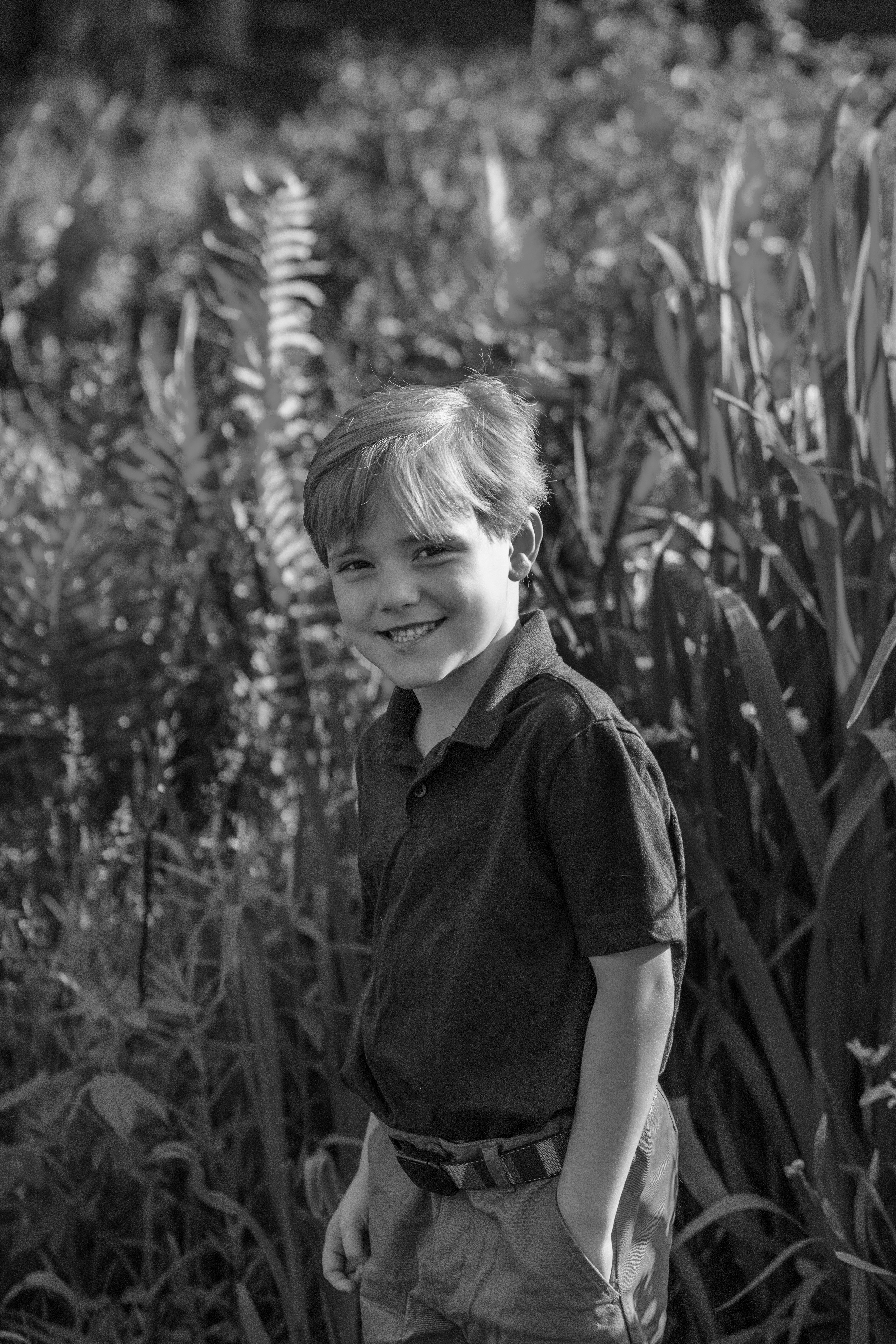 Child in a sunlit garden: a candid, grayscale portrait