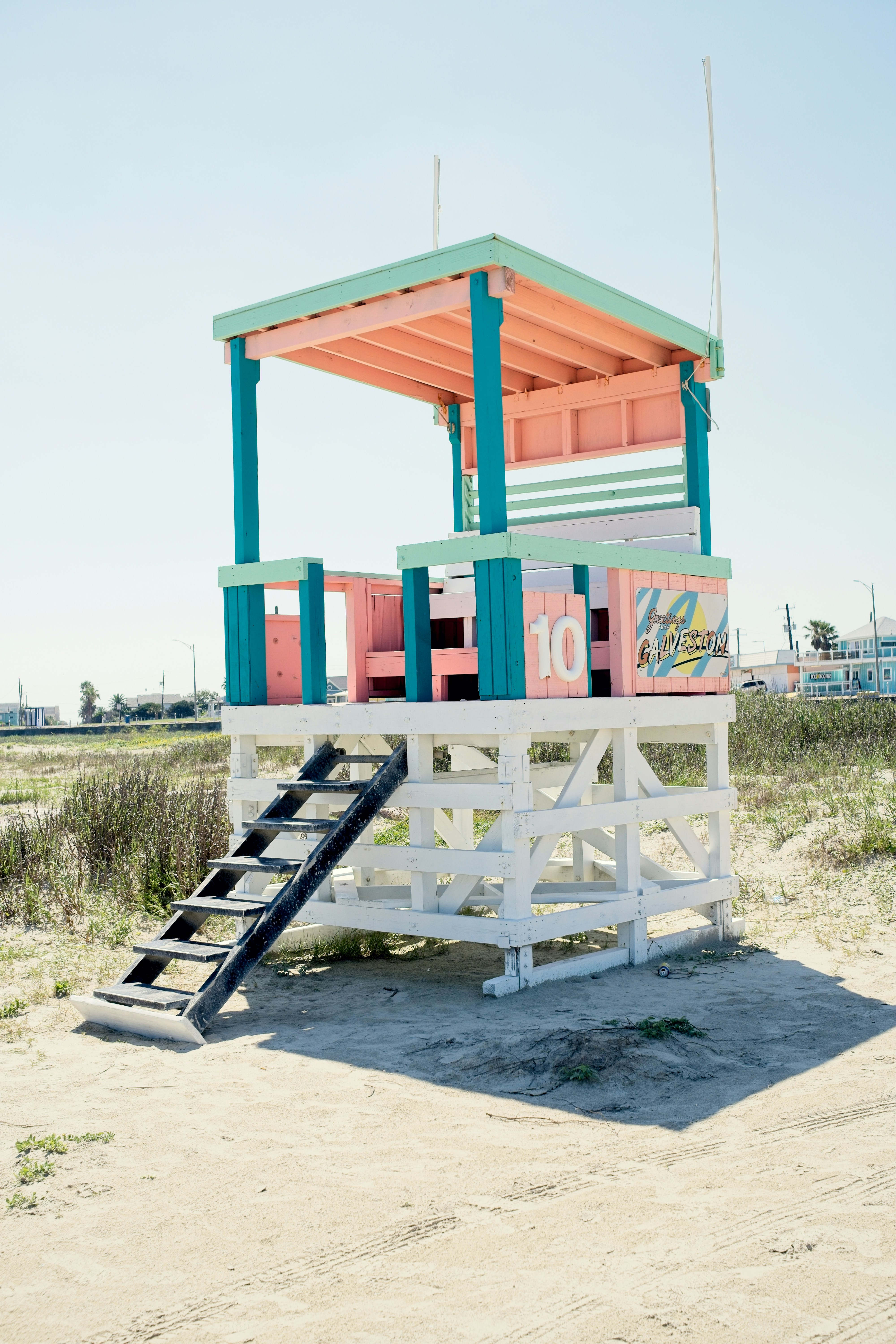Colorful lifeguard shack rising from sunlit dunes