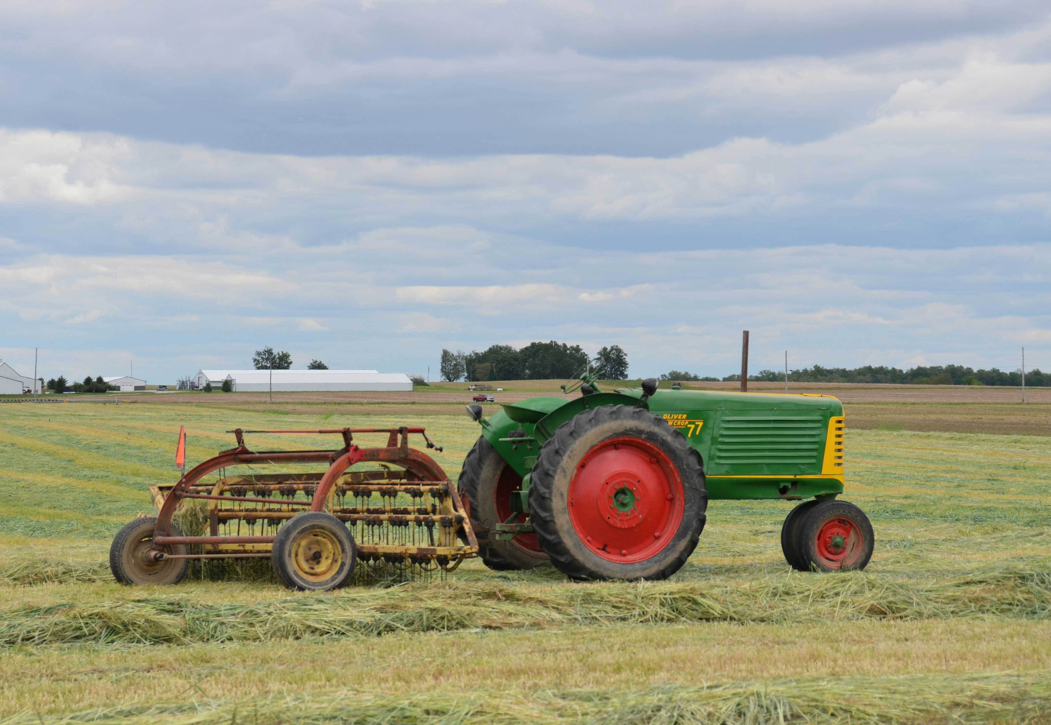 Green Tractor with Red Wheels in a Harvest Field