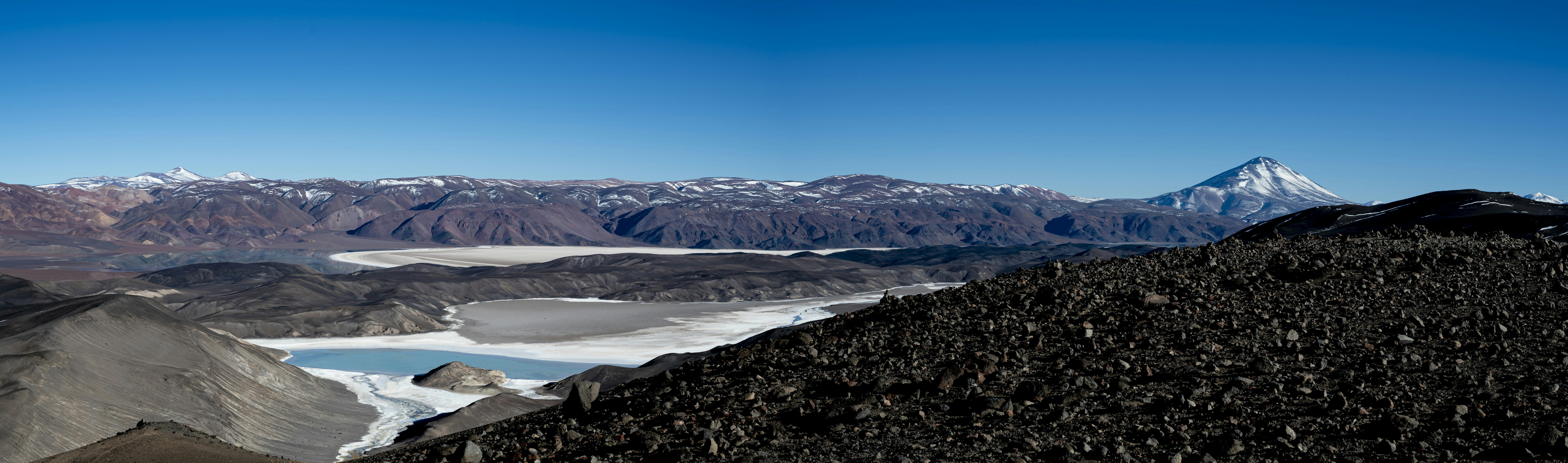Desert Basin Under a Cerulean Sky: Snow-kissed Peaks Beyond a Charred Ridge