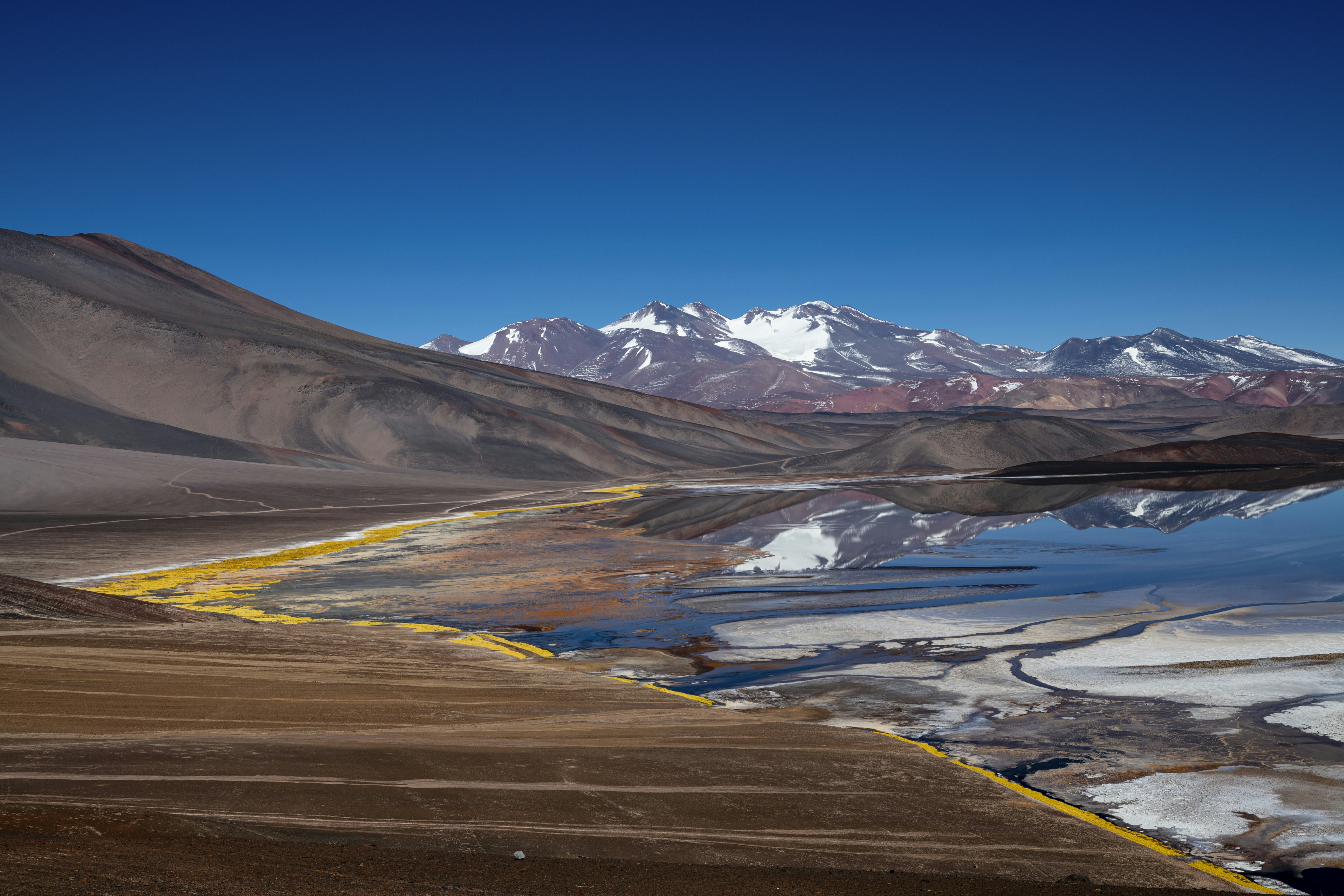 Desert Edge Reflections: Snow-Capped Peaks Framed by Dunes