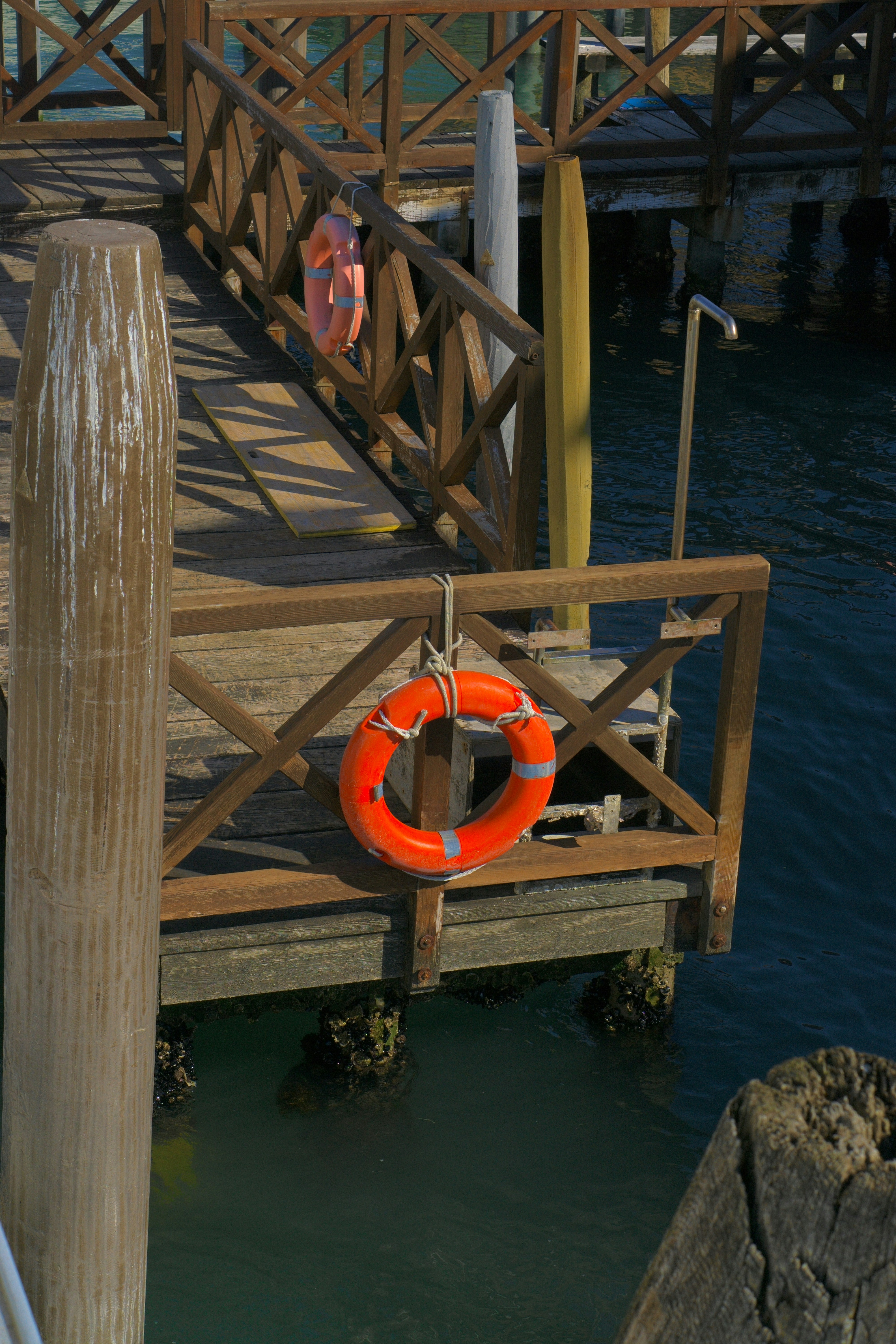 Bright Orange Lifeline Adrift Along the Wooden Dock