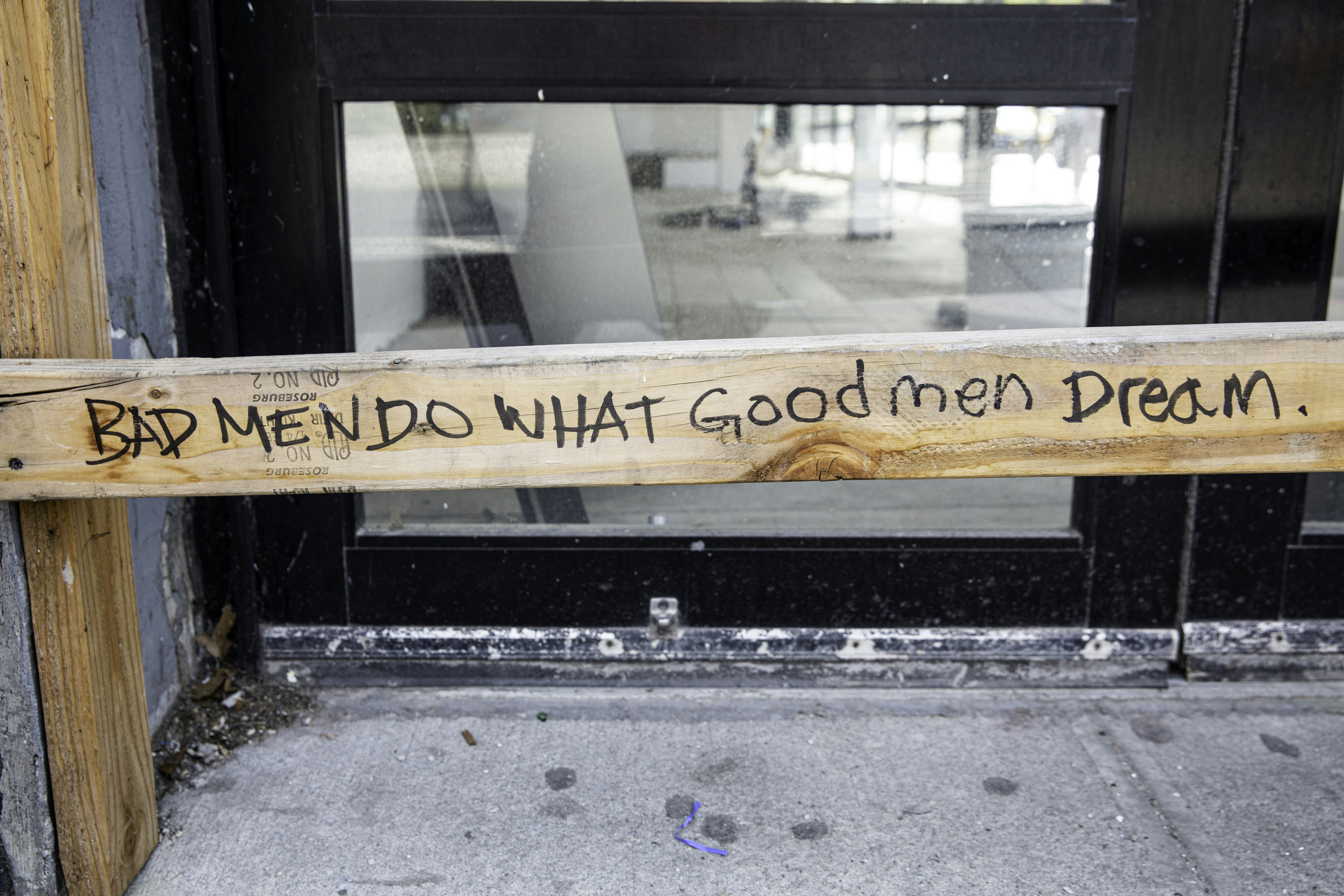 Graffiti on a Wooden Barrier Overlooking a Modern storefront