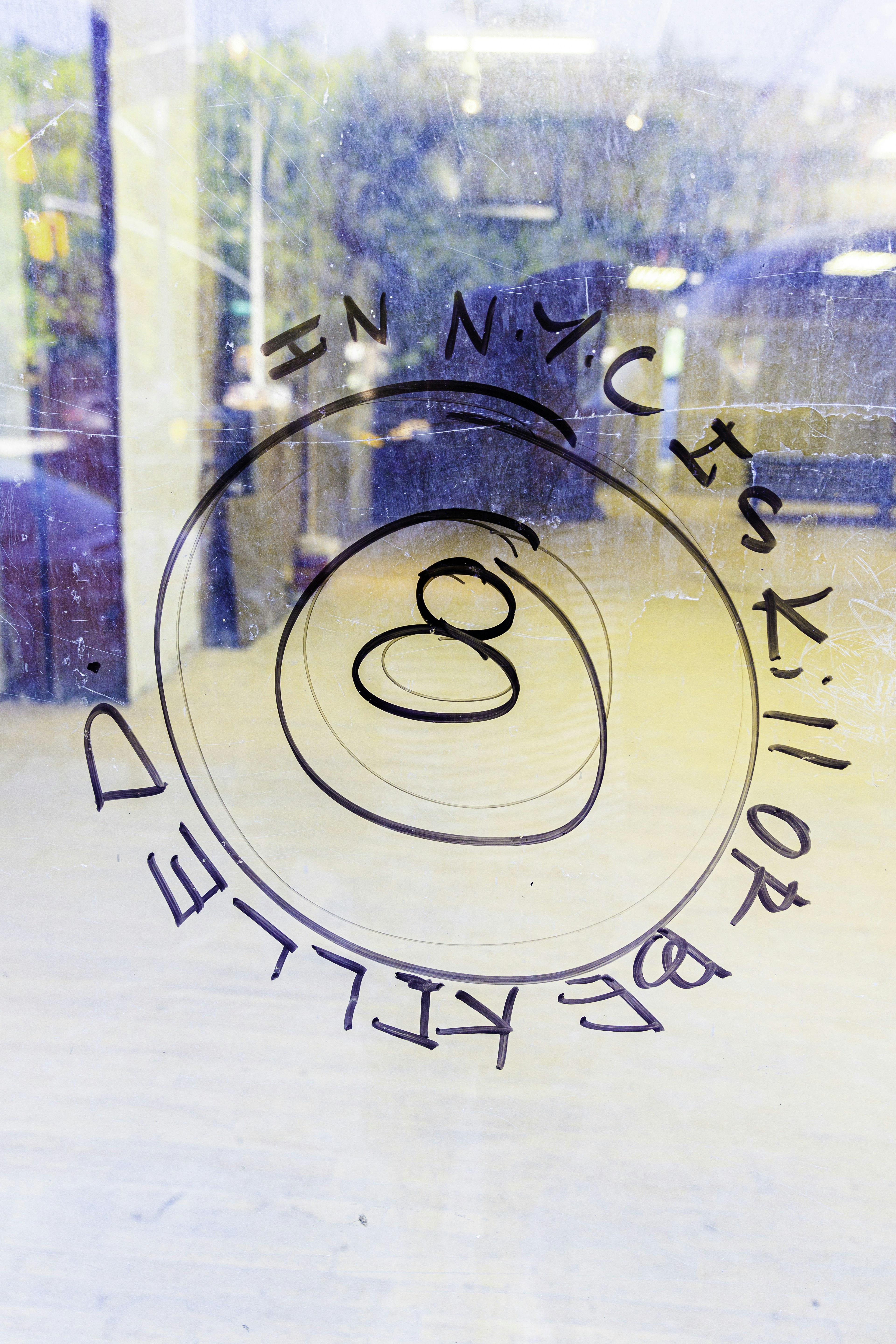 Circular logo etched on a glass storefront the center of a softly blurred interior